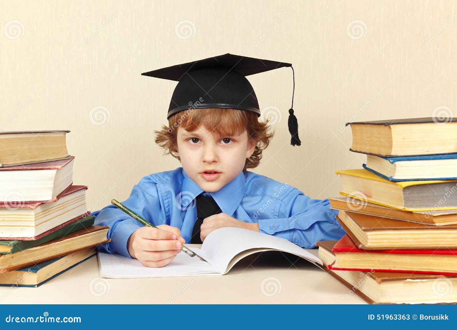 Little Boy in Academic Hat Writing Pen in Notebook among the Old Books ...
