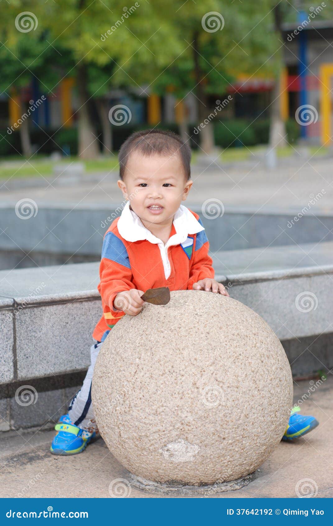 Little Boy Behind the Round Stone Stock Photo - Image of rely, stone ...
