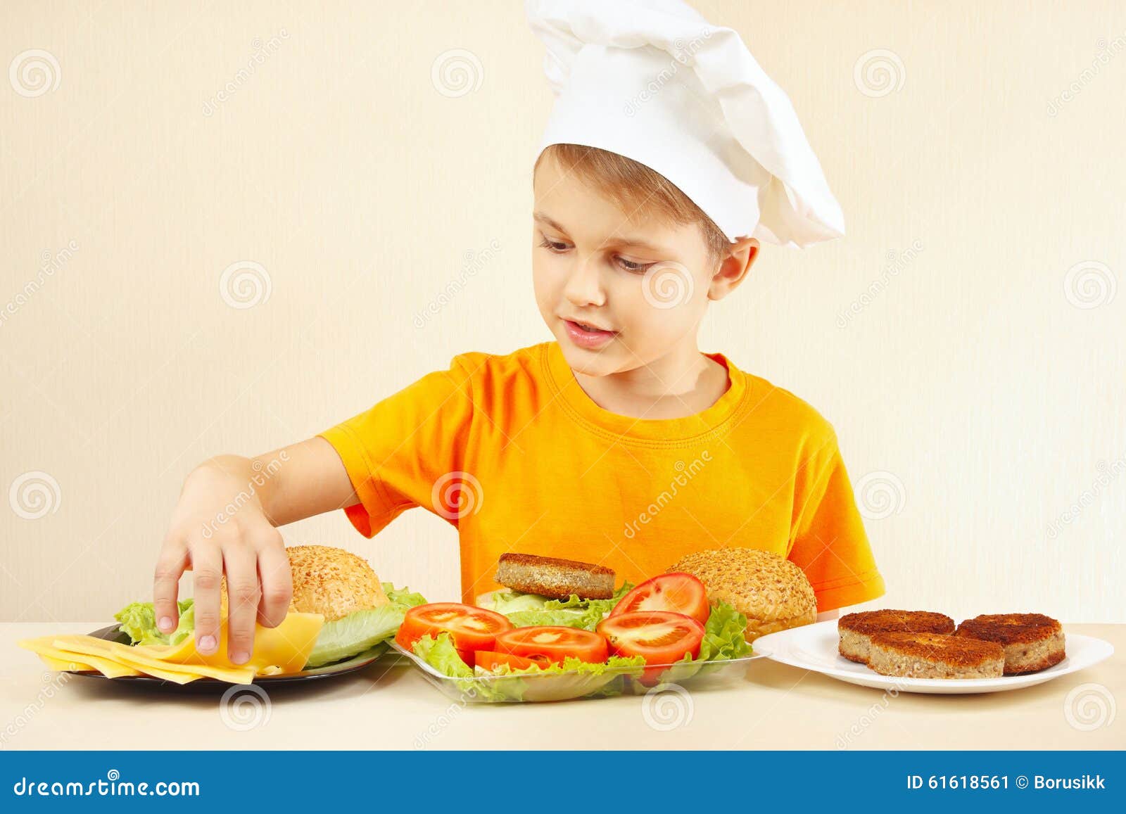 Little Boy in Chefs Hat Puts Cheese on Hamburger Stock Image - Image of ...