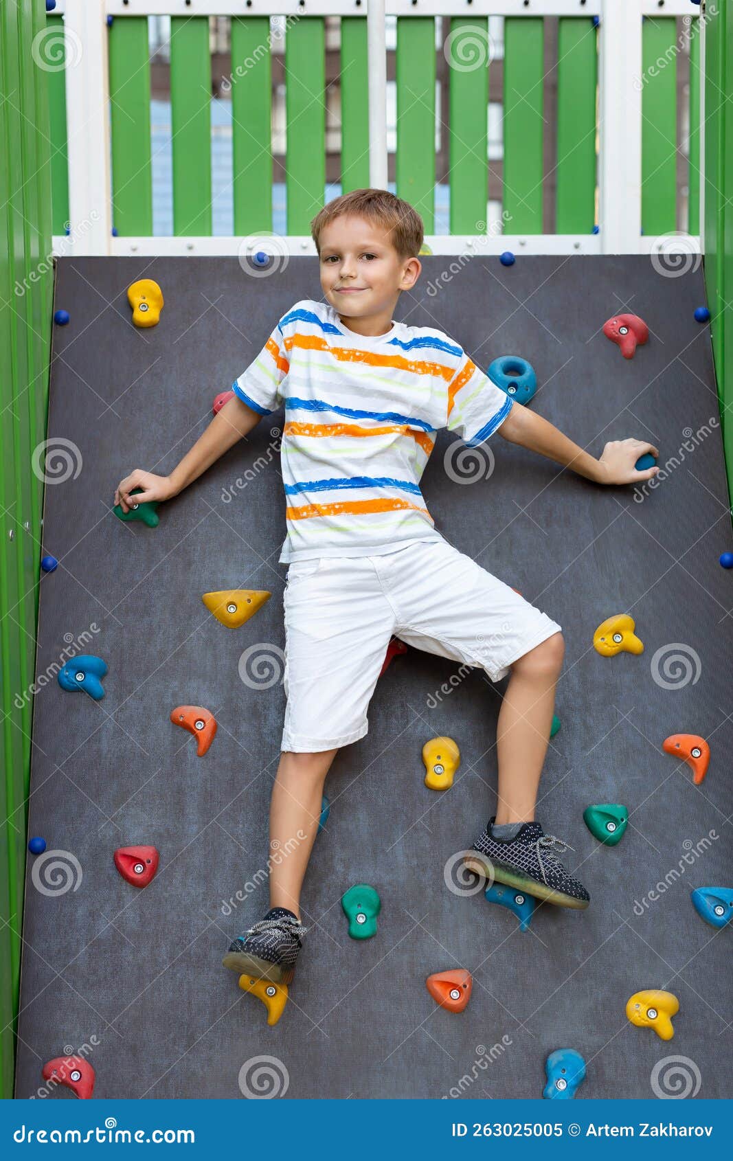 A Little Boy Climbs a Climbing Wall on a Modern Playground. Stock Image ...