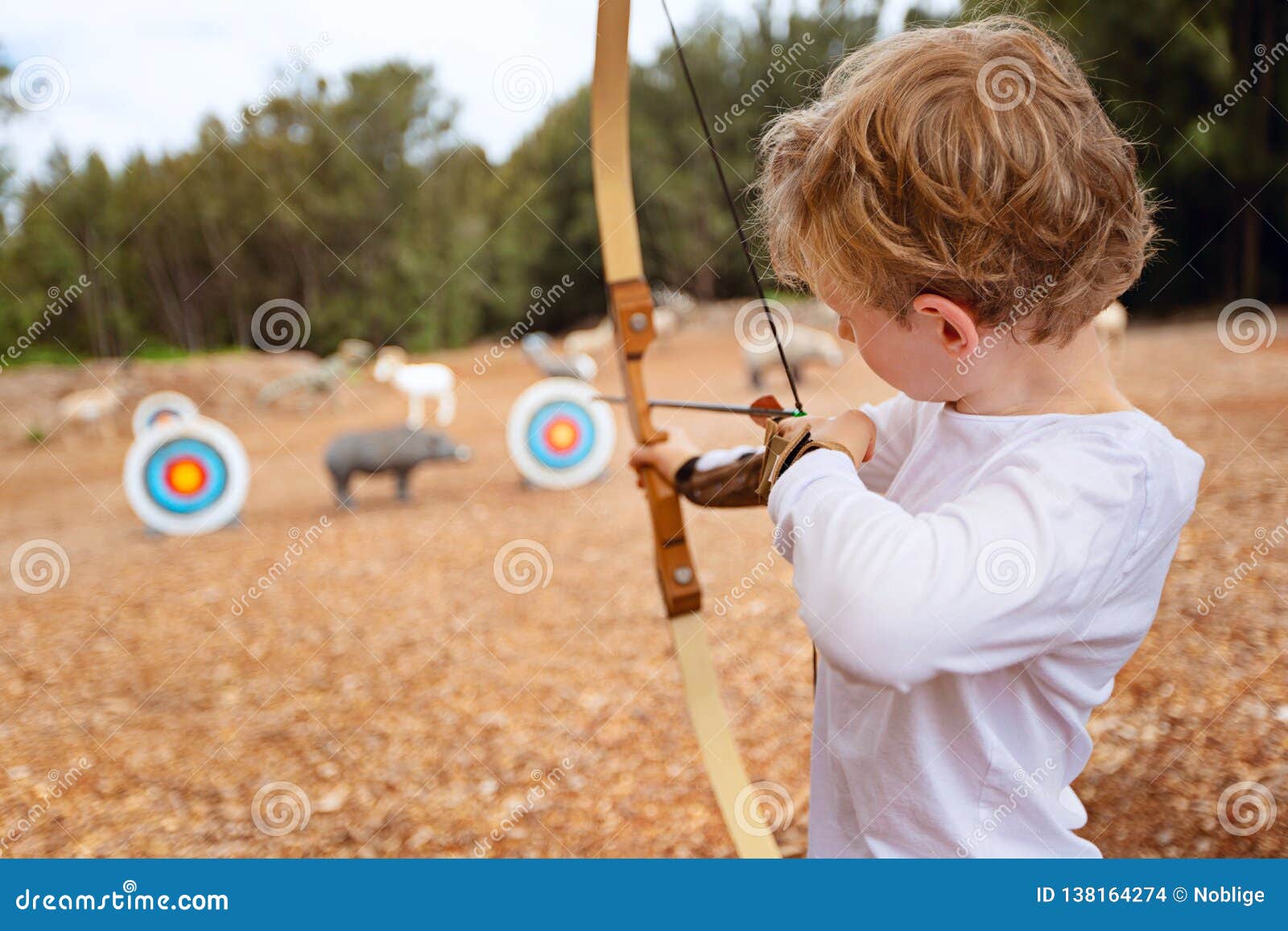 Kid practicing archery stock photo. Image of concentrated - 138164274
