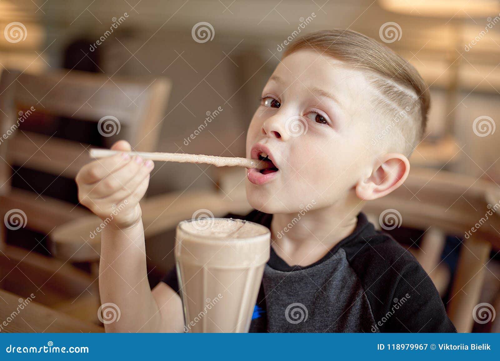 Little Boy Drinking Milkshake Sitting at the Table in Cafe Stock Image ...