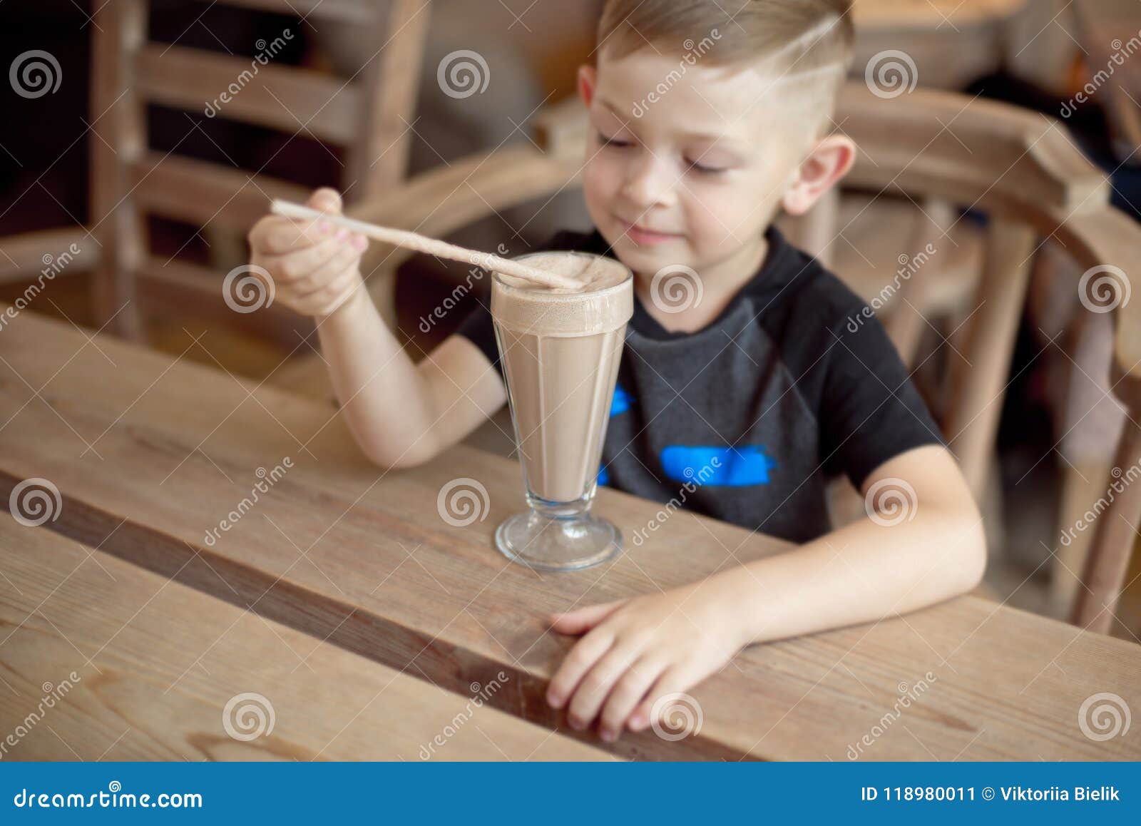 Little Boy Drinking Milkshake Sitting at the Table in Cafe Stock Image ...