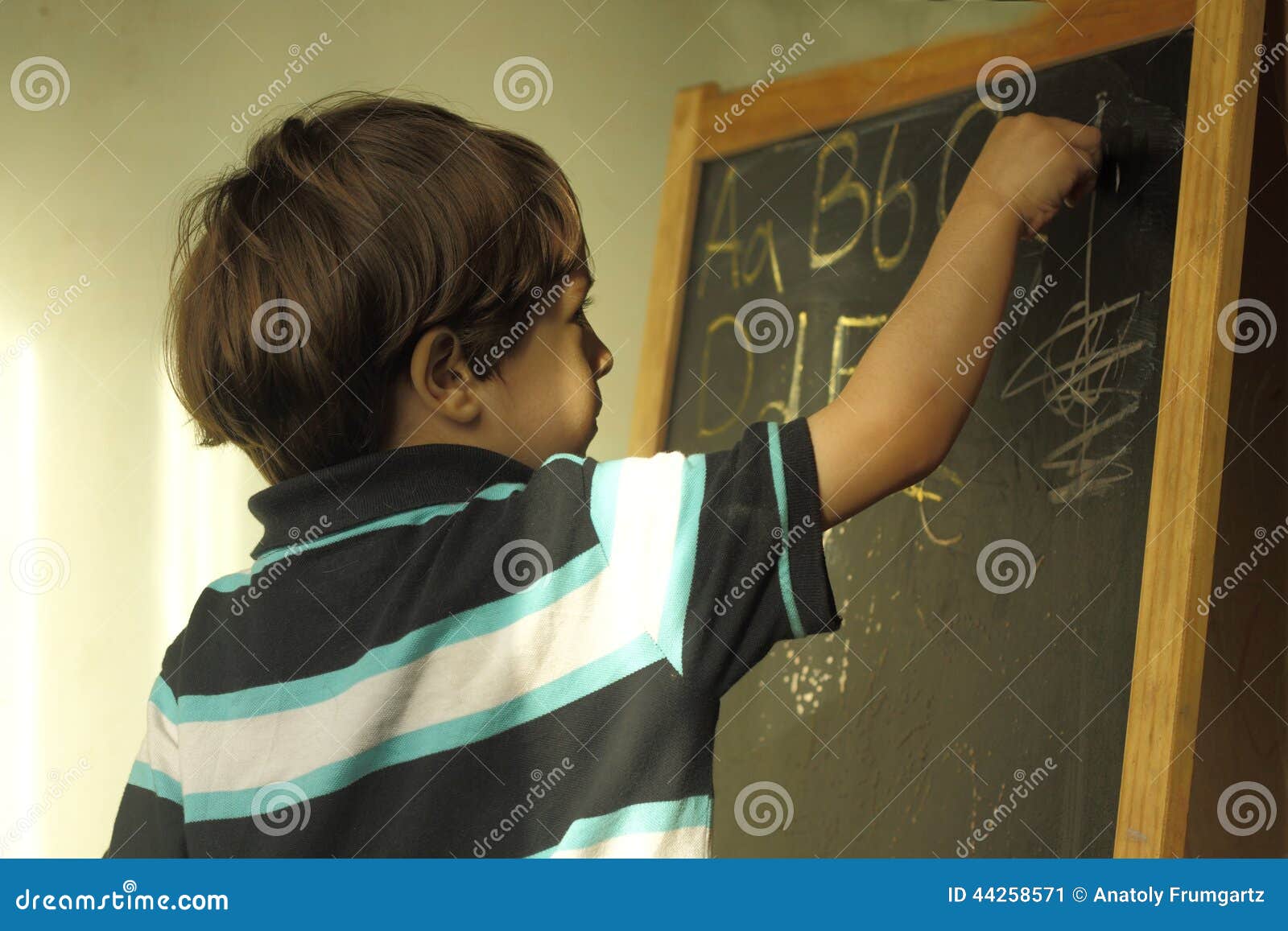 A Little Boy Writing on an Easel Stock Image - Image of blackboard ...