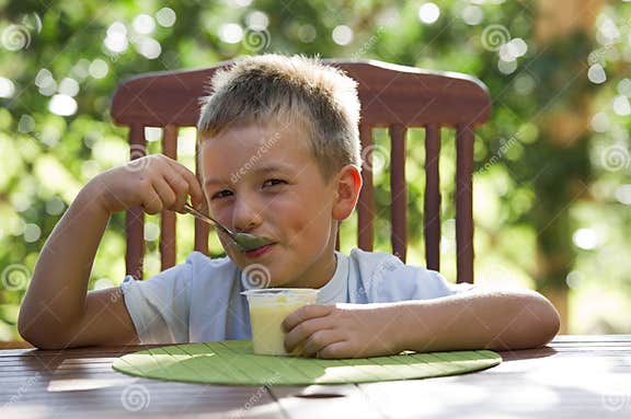 Little boy eating pudding stock photo. Image of male - 16870920