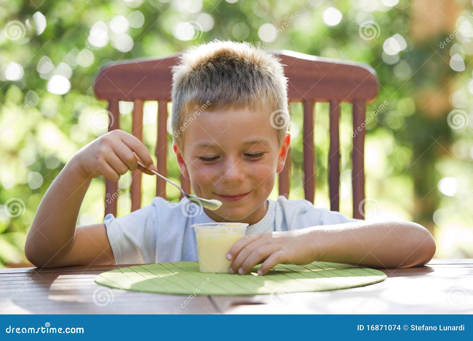 Little boy eating pudding stock photo. Image of cream - 16871074