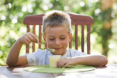 Little boy eating pudding stock photo. Image of cream - 16871074