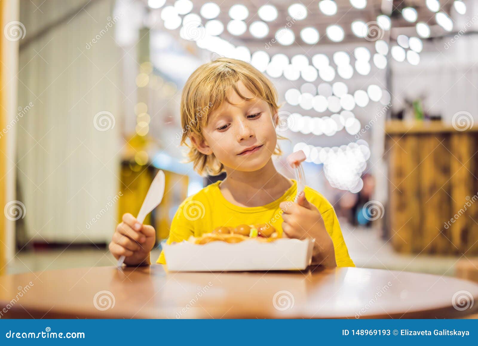 A Little Boy Eats Dessert Waffles with Jam in a Cafe Stock Image ...