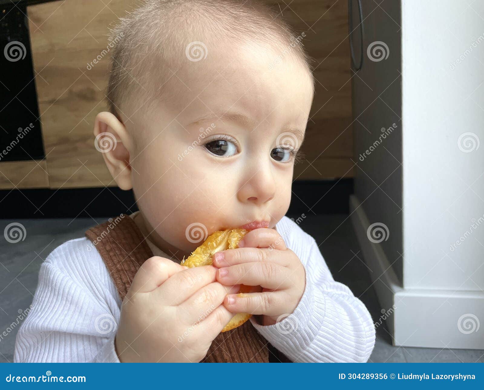 A Little Boy Eats a Piece of Orange by Himself Stock Photo - Image of ...