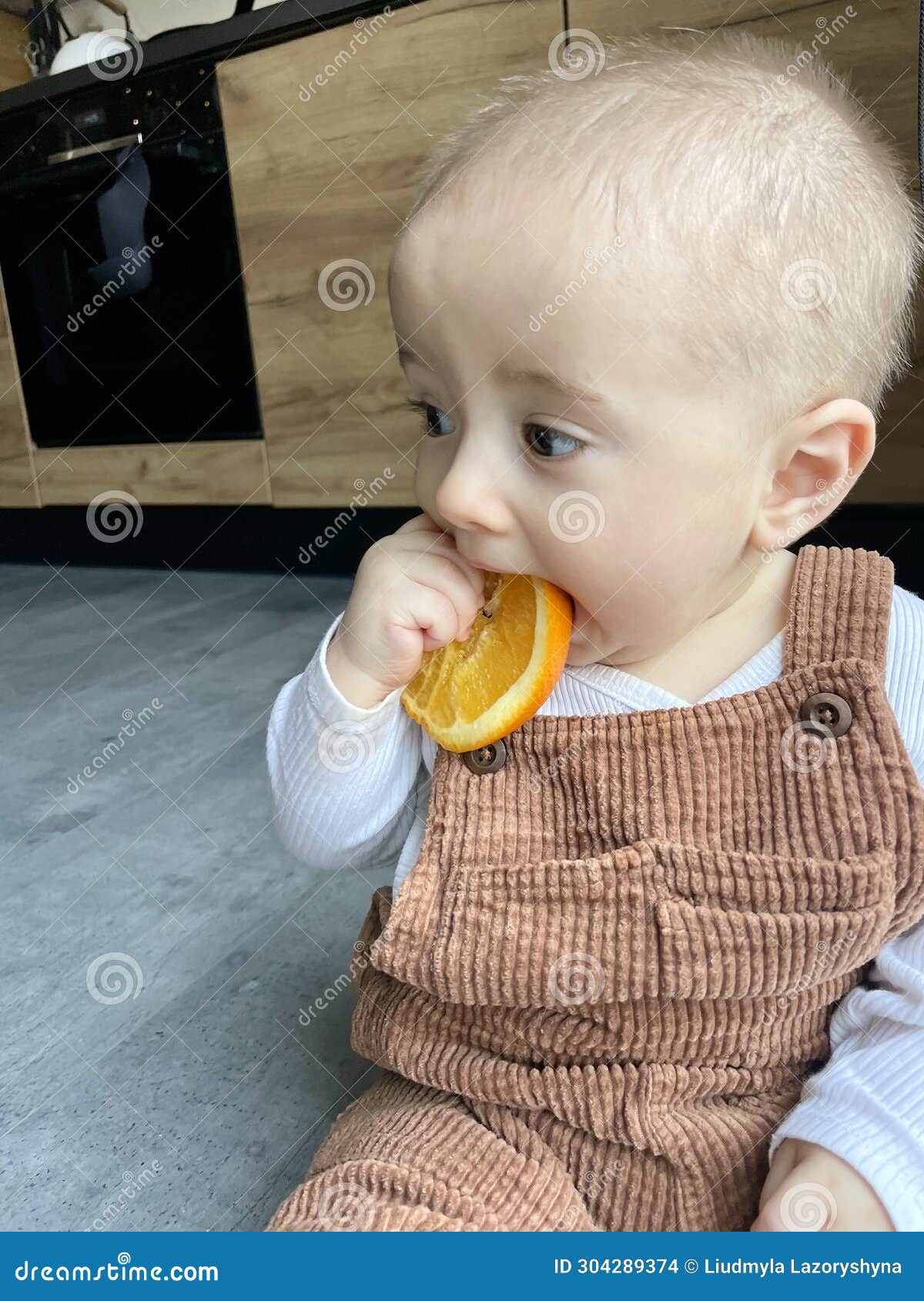 A Little Boy Eats a Piece of Orange by Himself Stock Photo - Image of ...