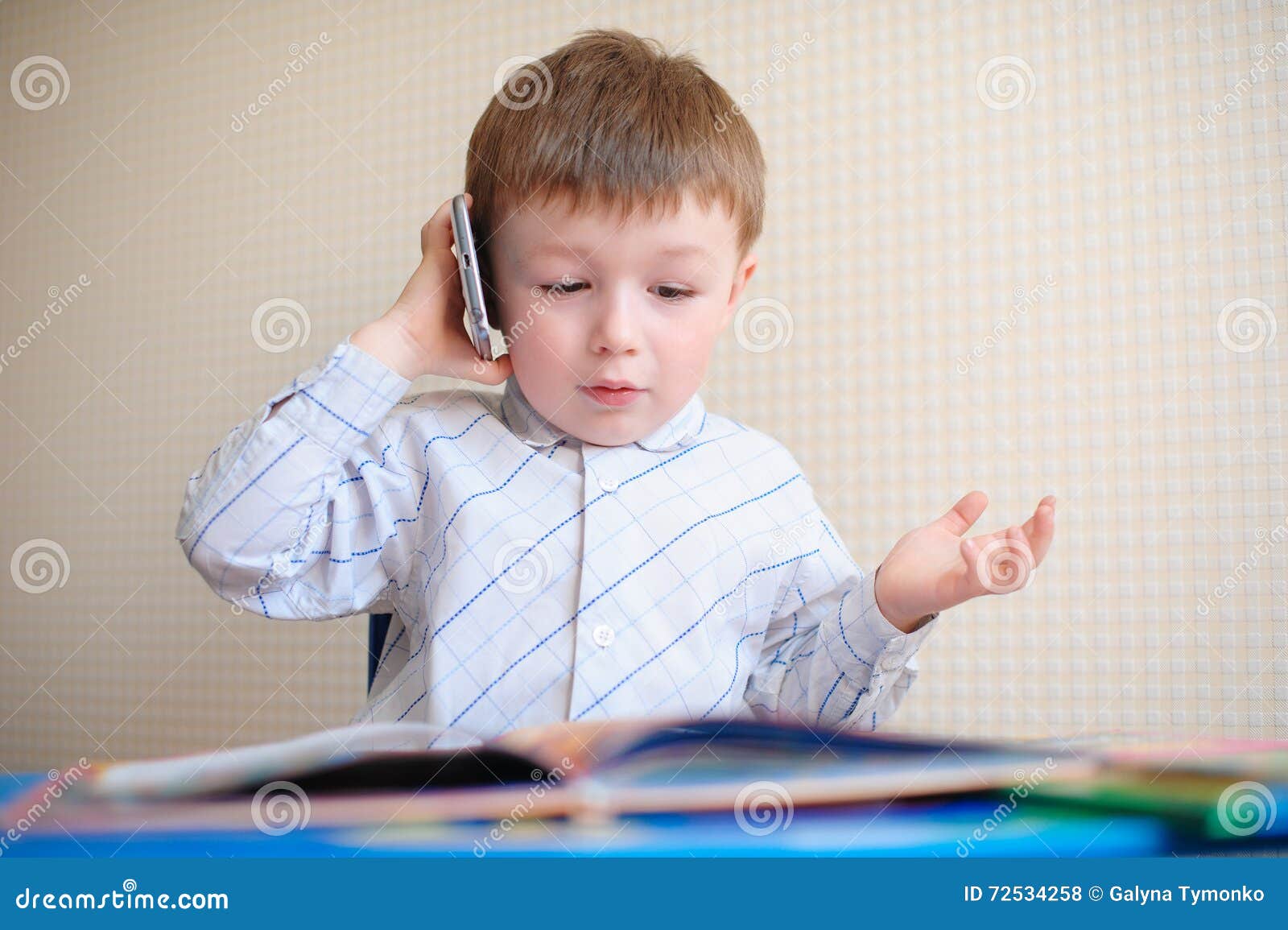 Little Boy Having a Serious Phone Call at Desk Stock Photo - Image of ...