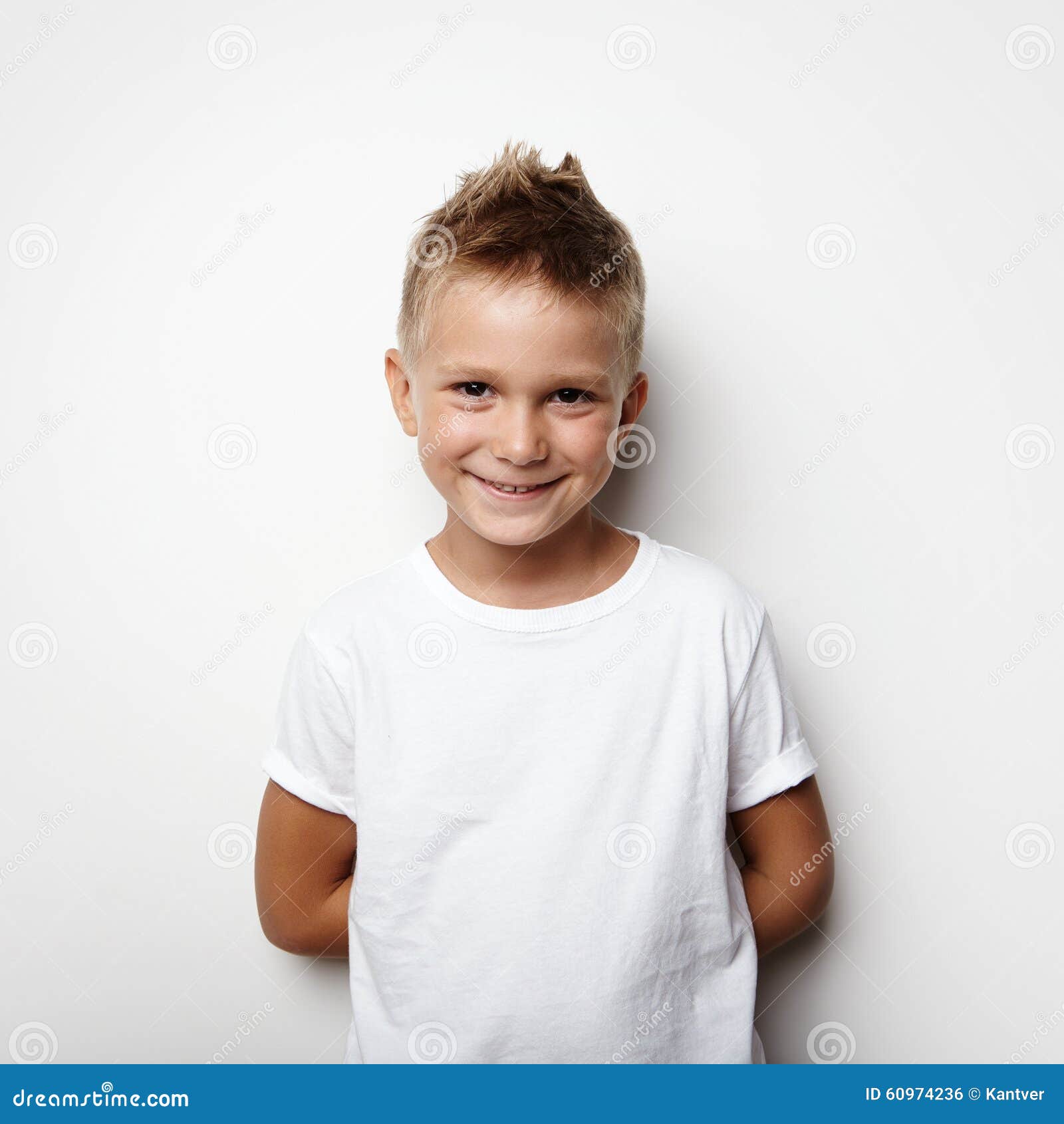 Little Boy Holds Hands Behind Back and Smiling on Stock Photo - Image ...