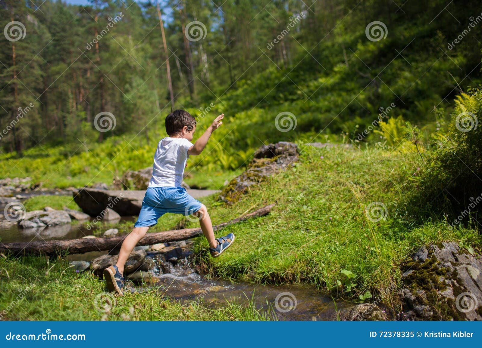 Little Boy Jumps Over a Stream in Forest Stock Image - Image of ...