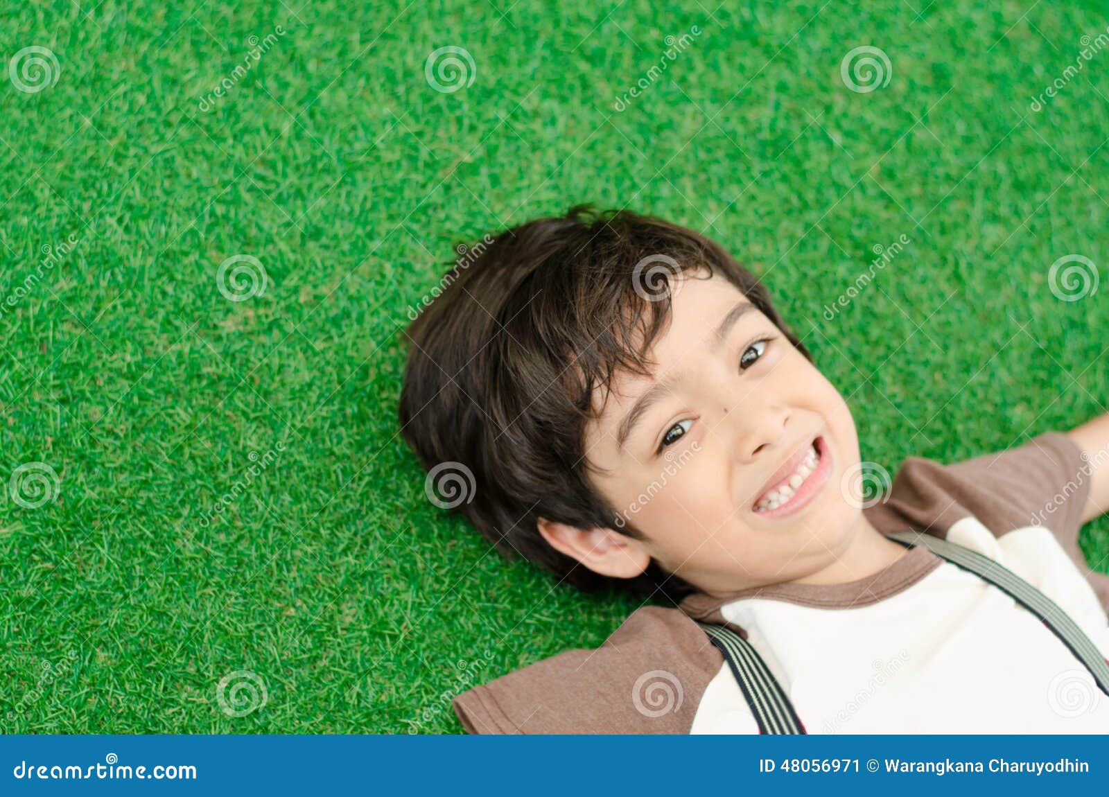 Little Boy Lay Down on Green Grass Stock Image - Image of smile, happy ...