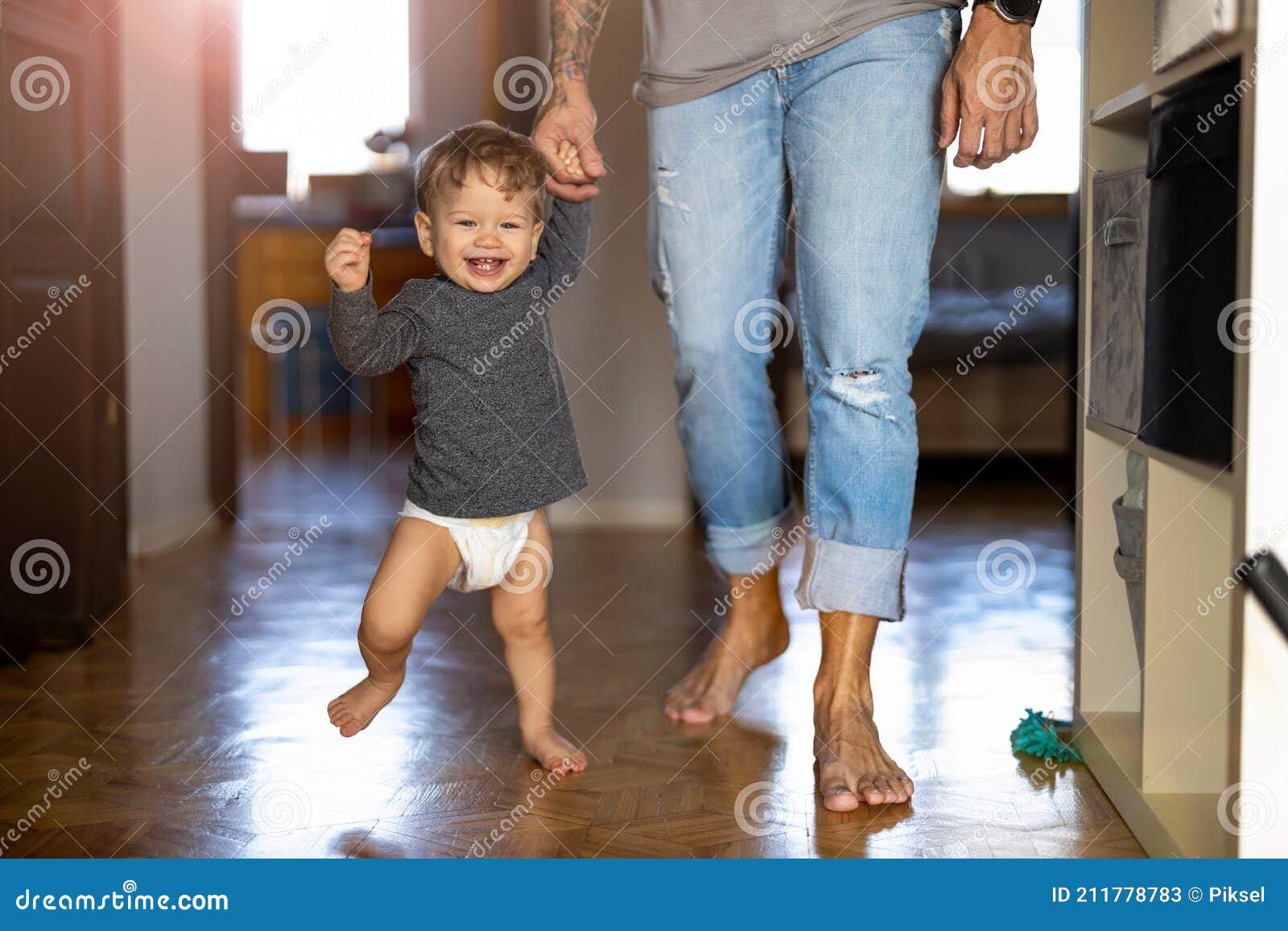 Little Boy Learning To Walk with His Father Next To Him Stock Image ...