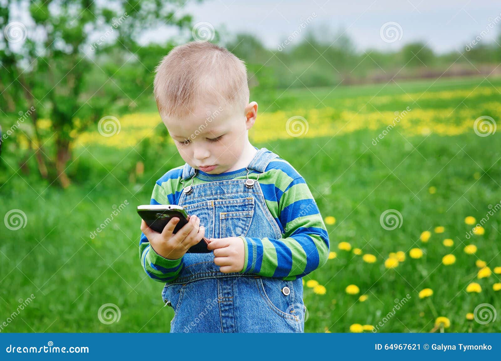 Little Boy Looking at a Smartphone on a Meadow Stock Image - Image of ...