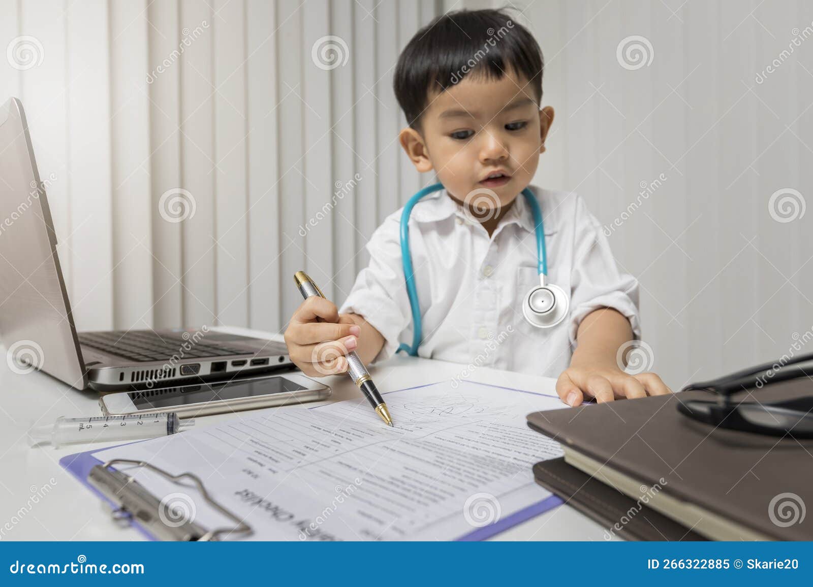 Little Boy in Medic Uniform Using a Pen on Desk Stock Image - Image of ...