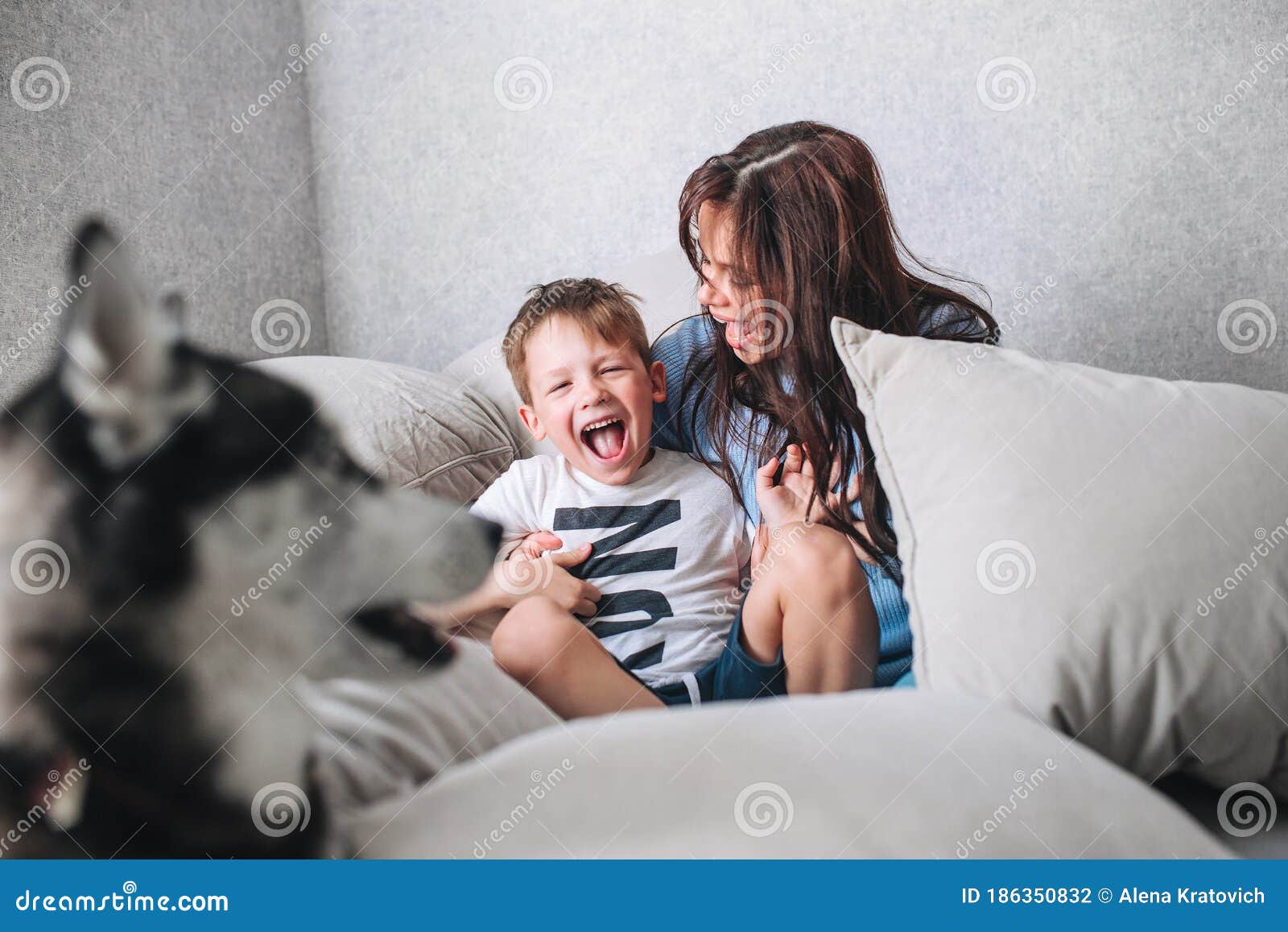 Little Boy Nickering and Playing with Mom and Dog at Home Stock Photo ...