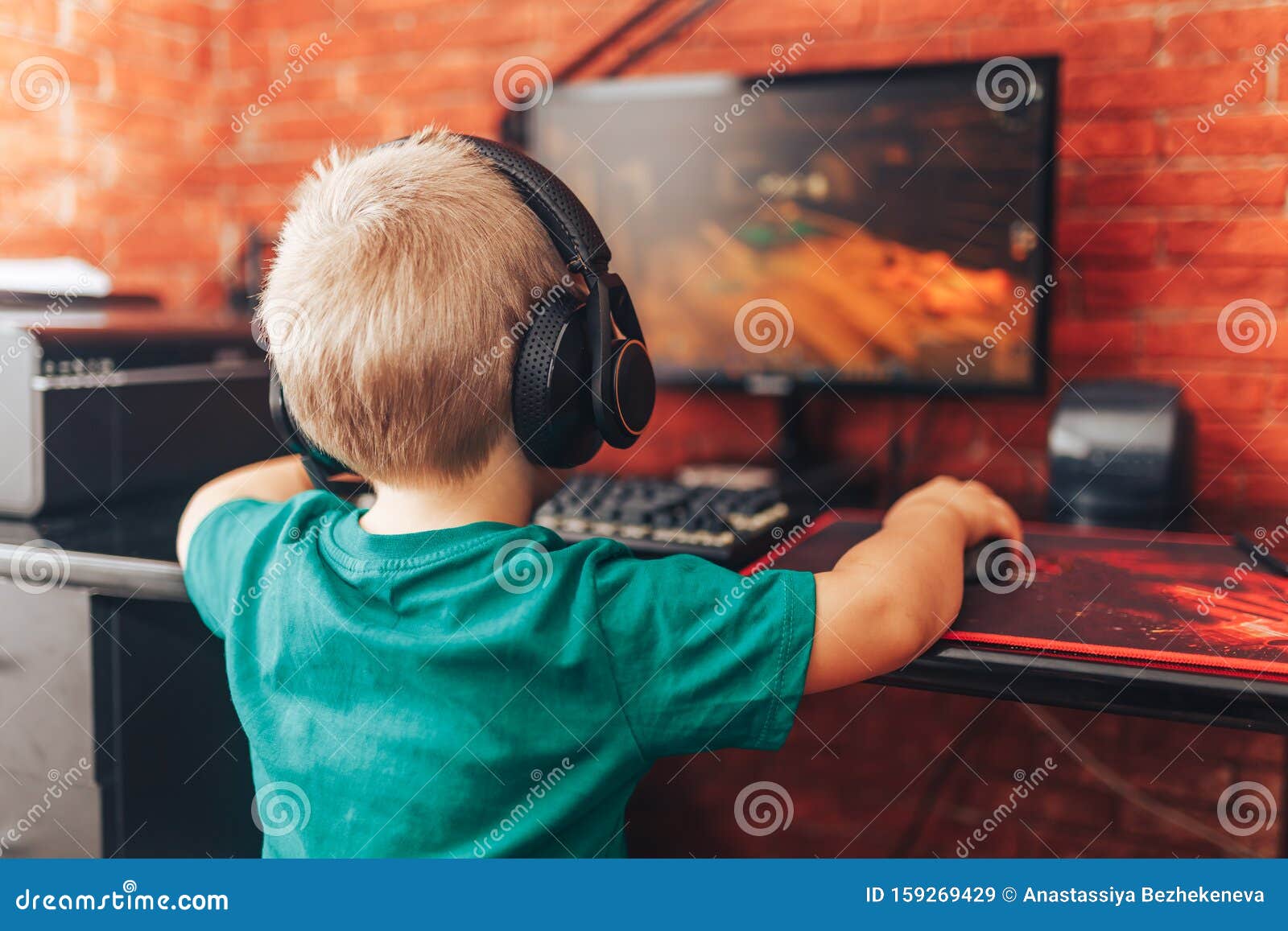 Little Boy Playing Games on Computer in Headphones with Microphone ...