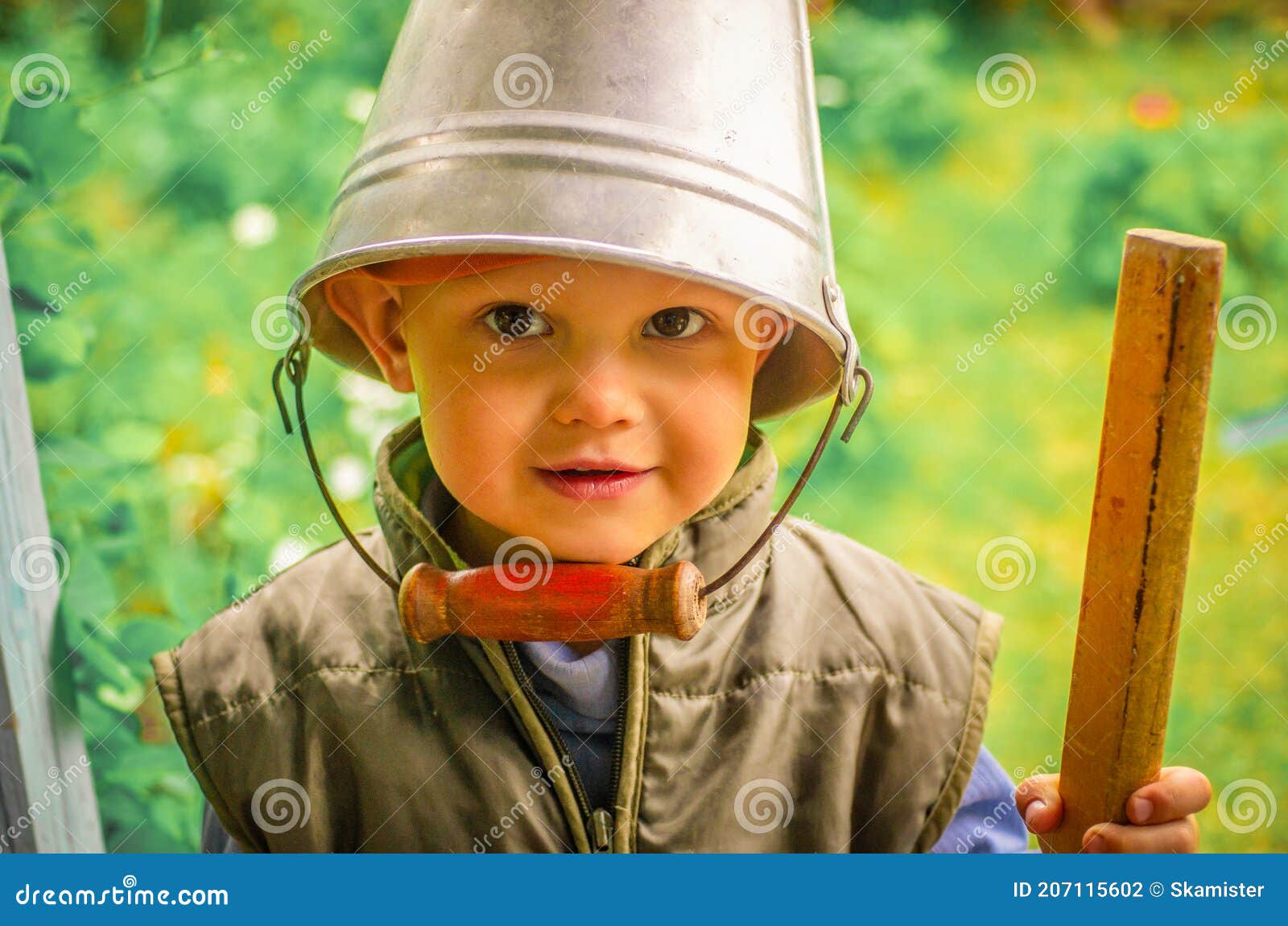 Little Boy Playing with a Stick and a Bucket on His Head Stock Photo ...