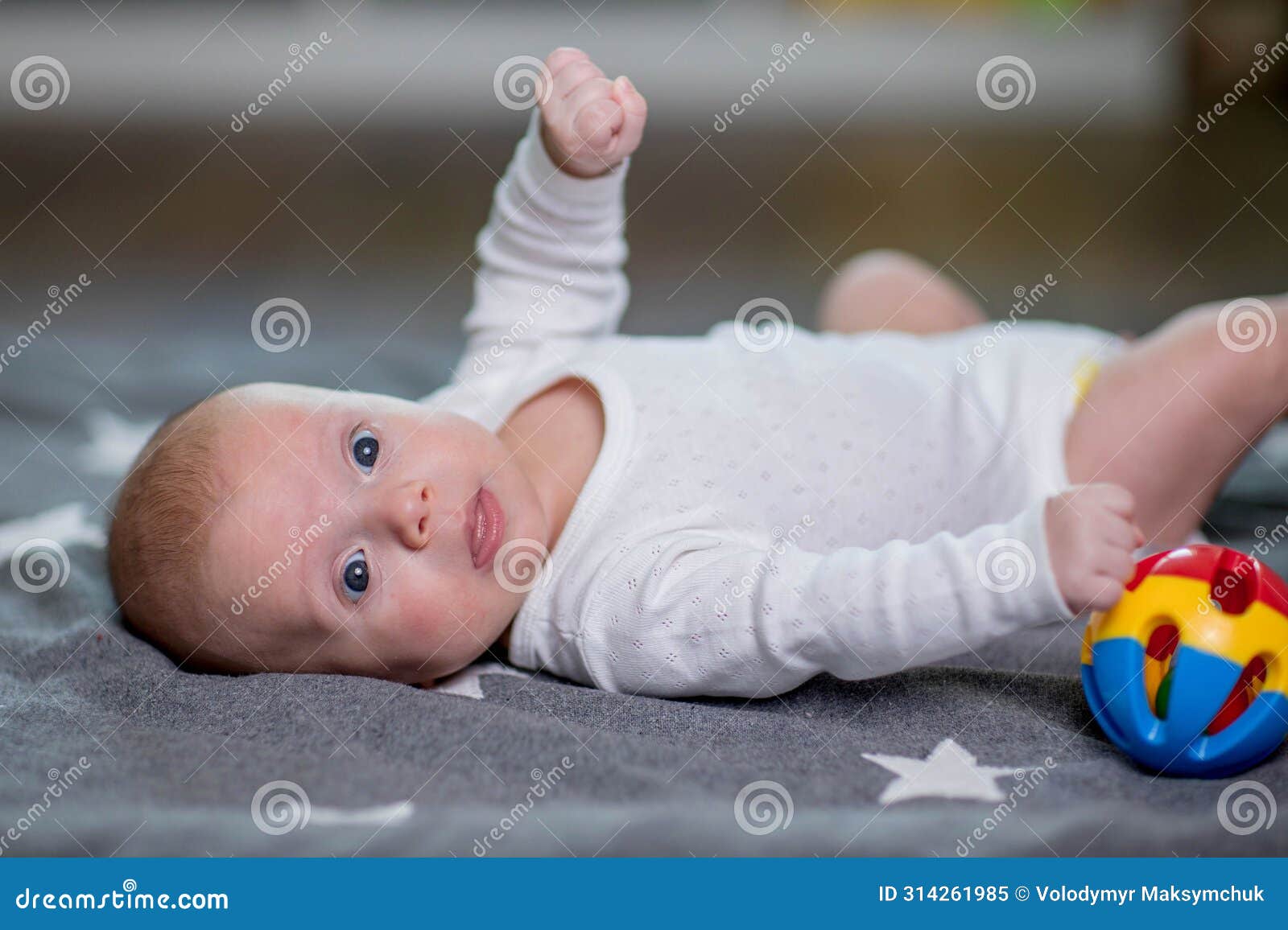 Little Boy is Playing with a Toy while Lying on His Back. Stock Image ...