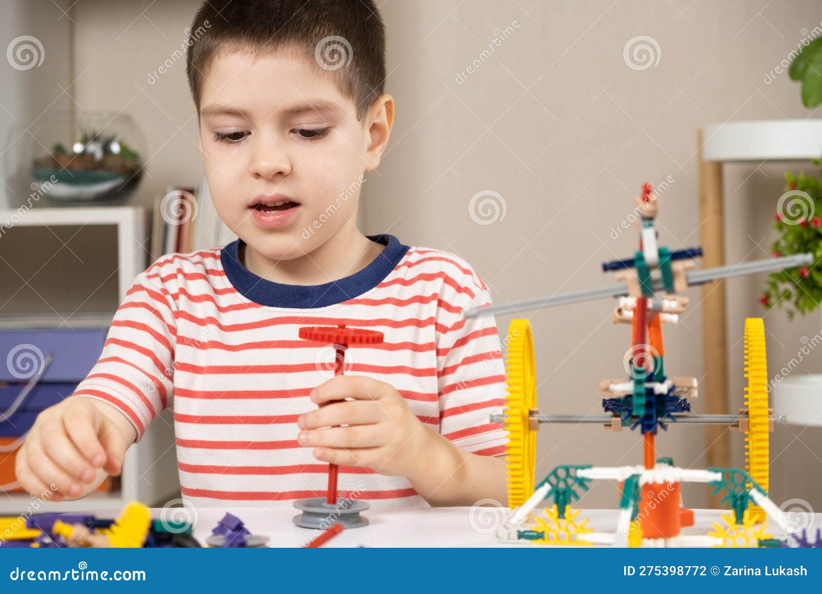 A Little Boy Plays with a Constructor, Creating Figures from Gears and ...