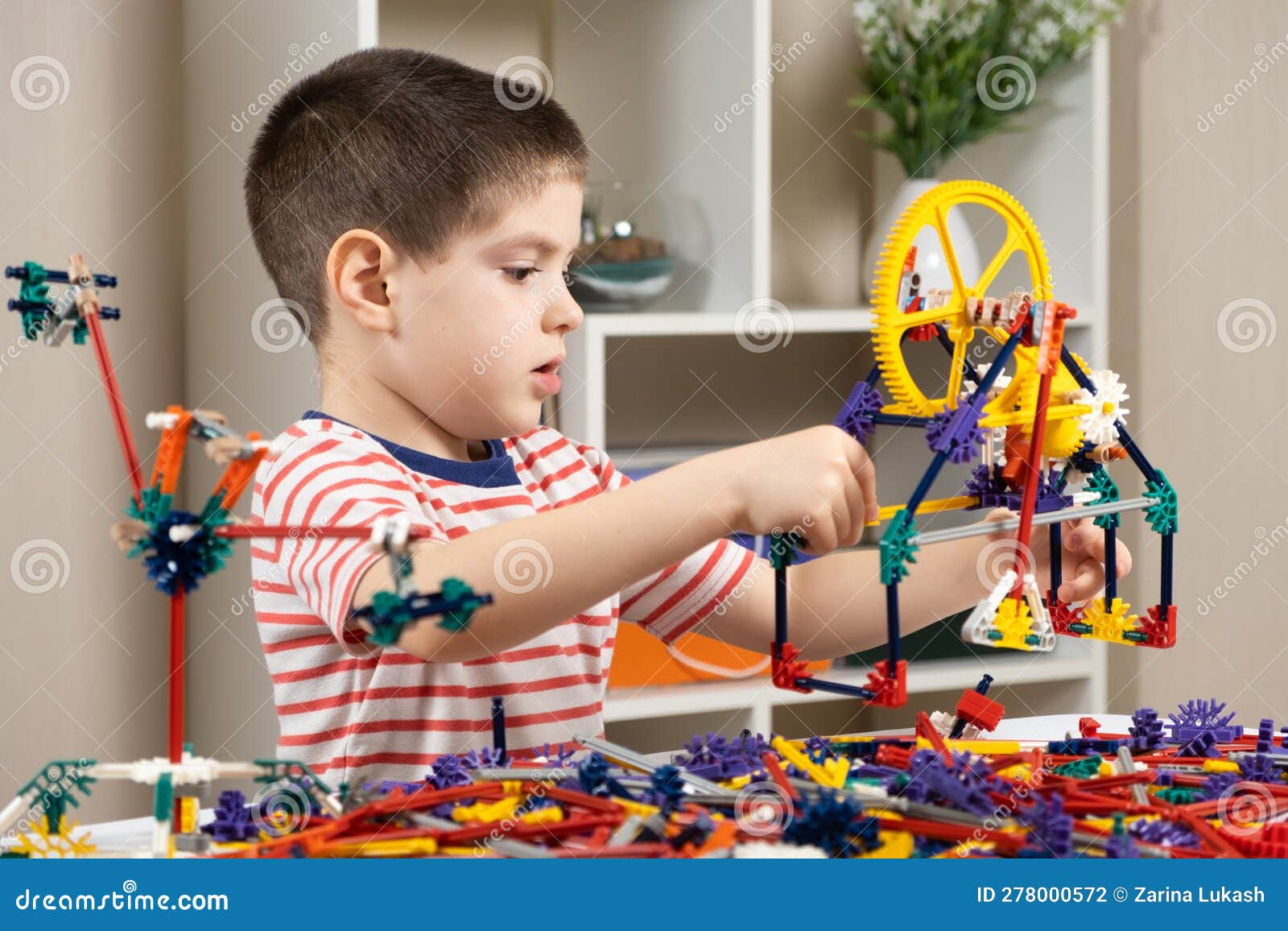 A Little Boy Plays with a Constructor, Creating Figures from Gears and ...