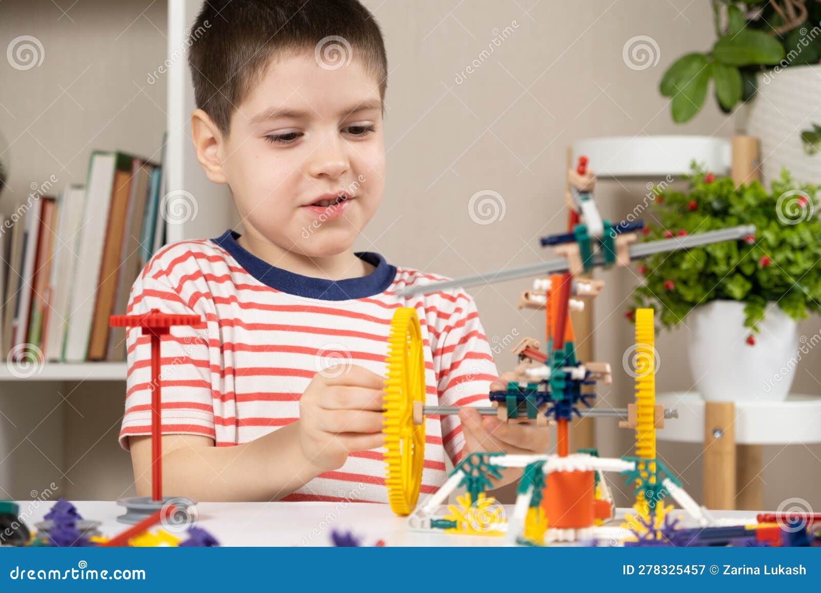 A Little Boy Plays with a Constructor, Creating Figures from Gears and ...