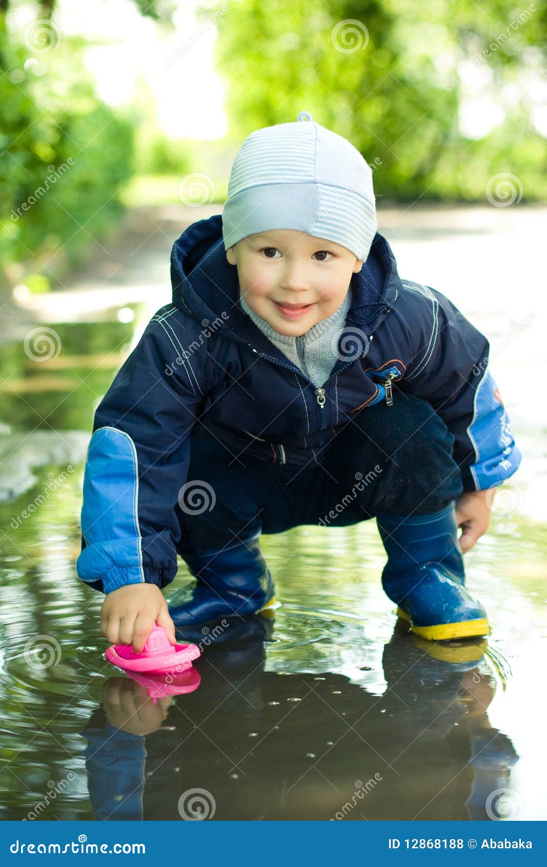 Little Boy Plays in the Puddle Stock Photo - Image of rainboots, coat ...
