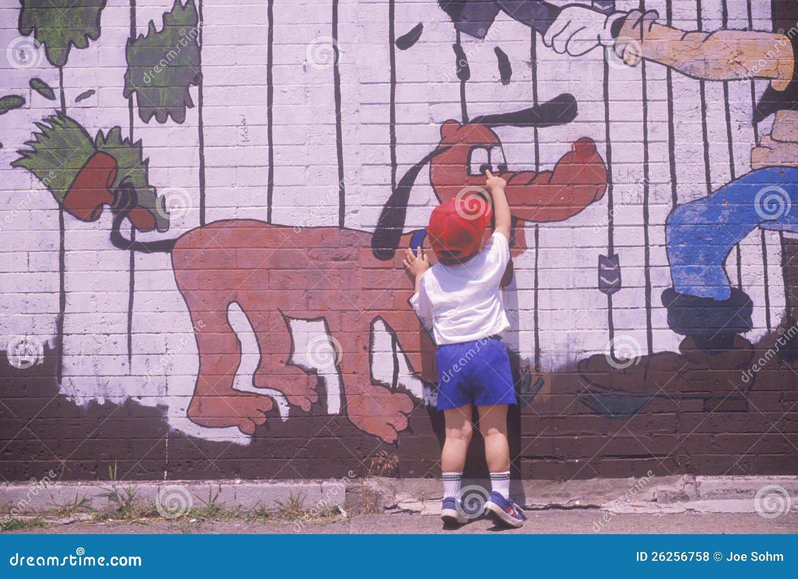A Little Boy Pointing To a Graffiti Character Editorial Stock Photo ...