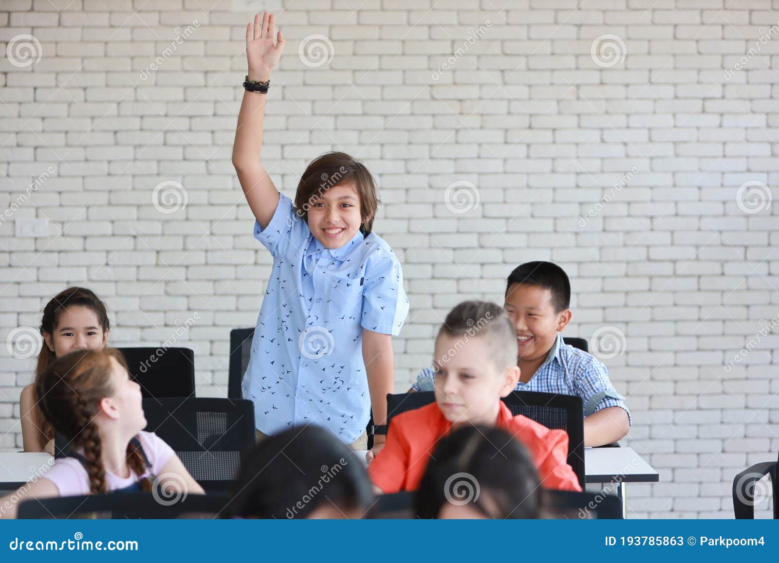 Little Boy Raising Hands in Classroom Education Concept Stock Image ...