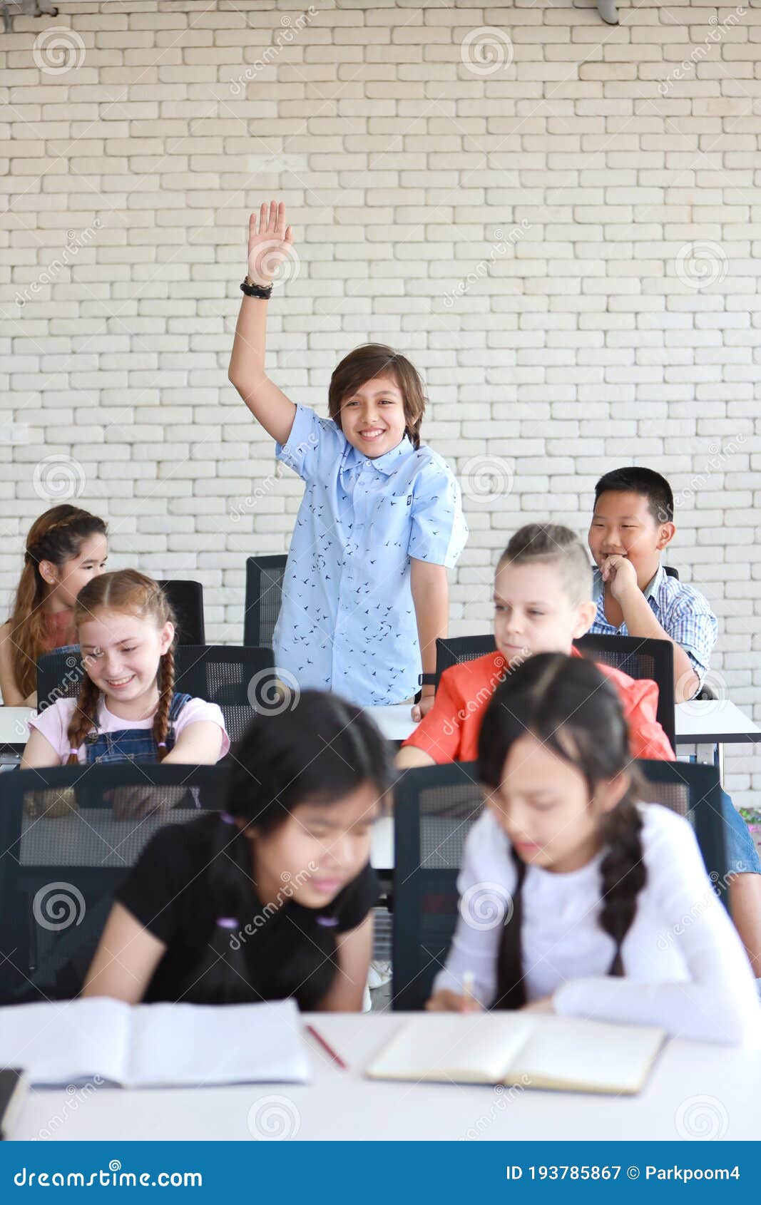Little Boy Raising Hands in Classroom Education Concept Stock Image ...
