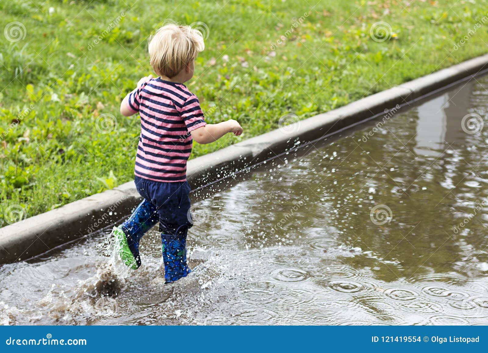 Little Boy Running into the Puddle. Toddler Playing in the Park Stock ...