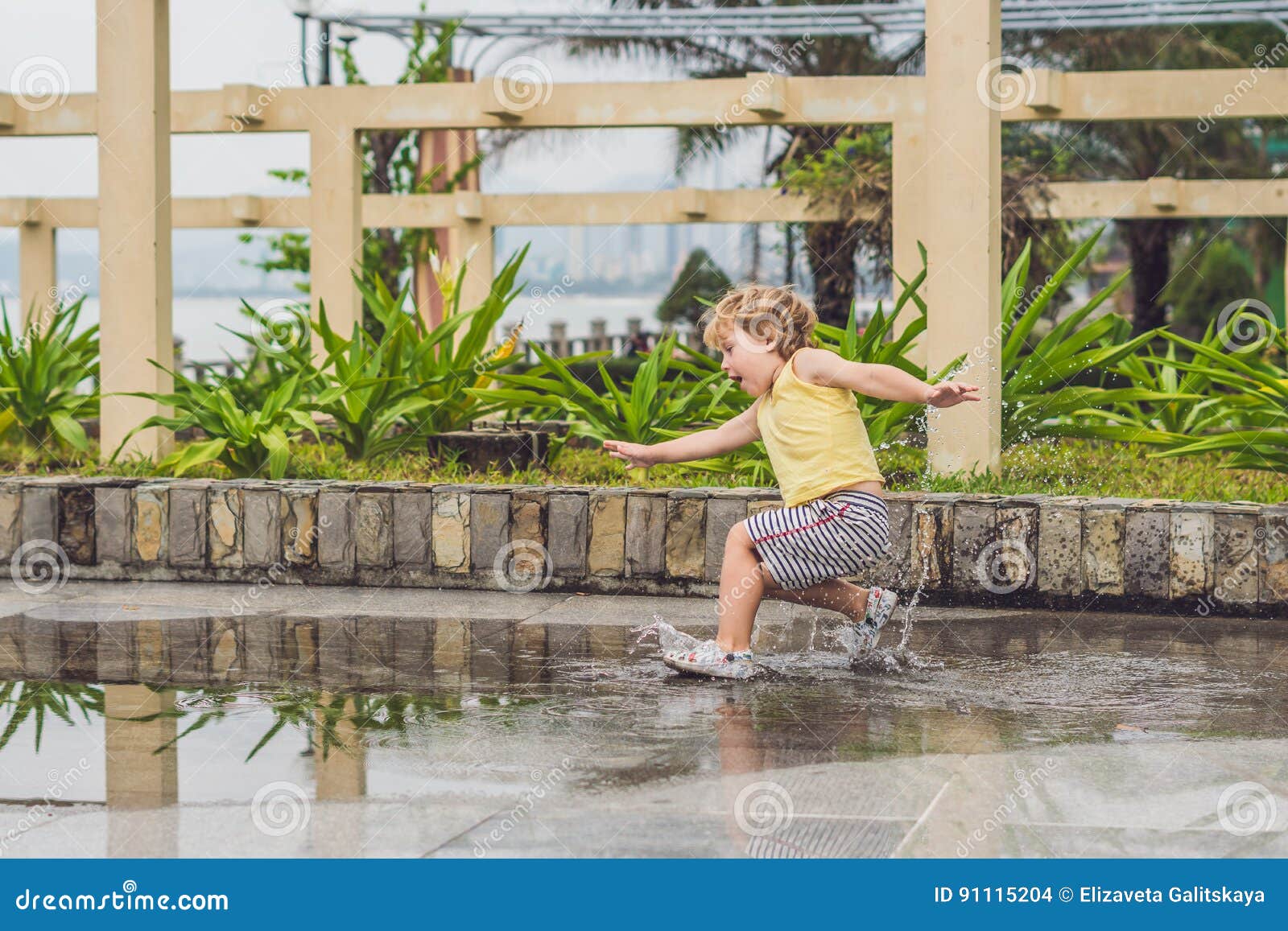 Little Boy Runs through a Puddle. Summer Outdoor Stock Photo - Image of ...