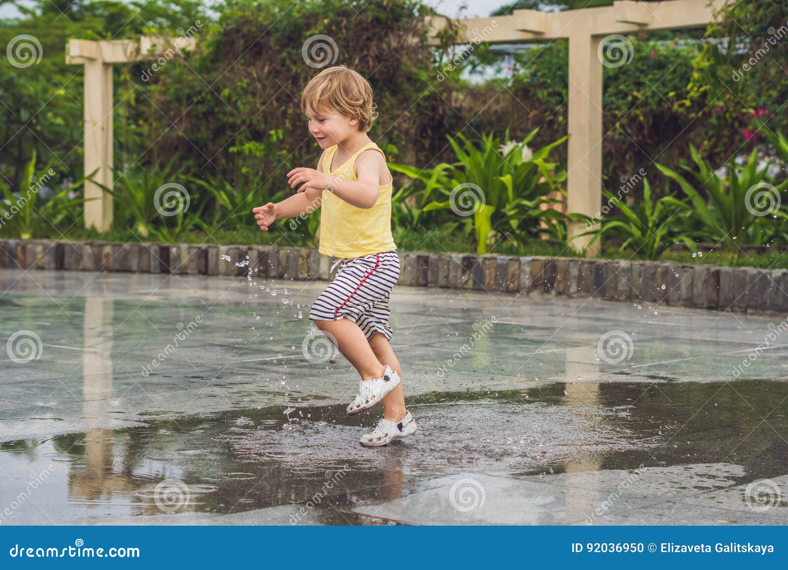 Little Boy Runs through a Puddle. Summer Outdoor Stock Photo - Image of ...