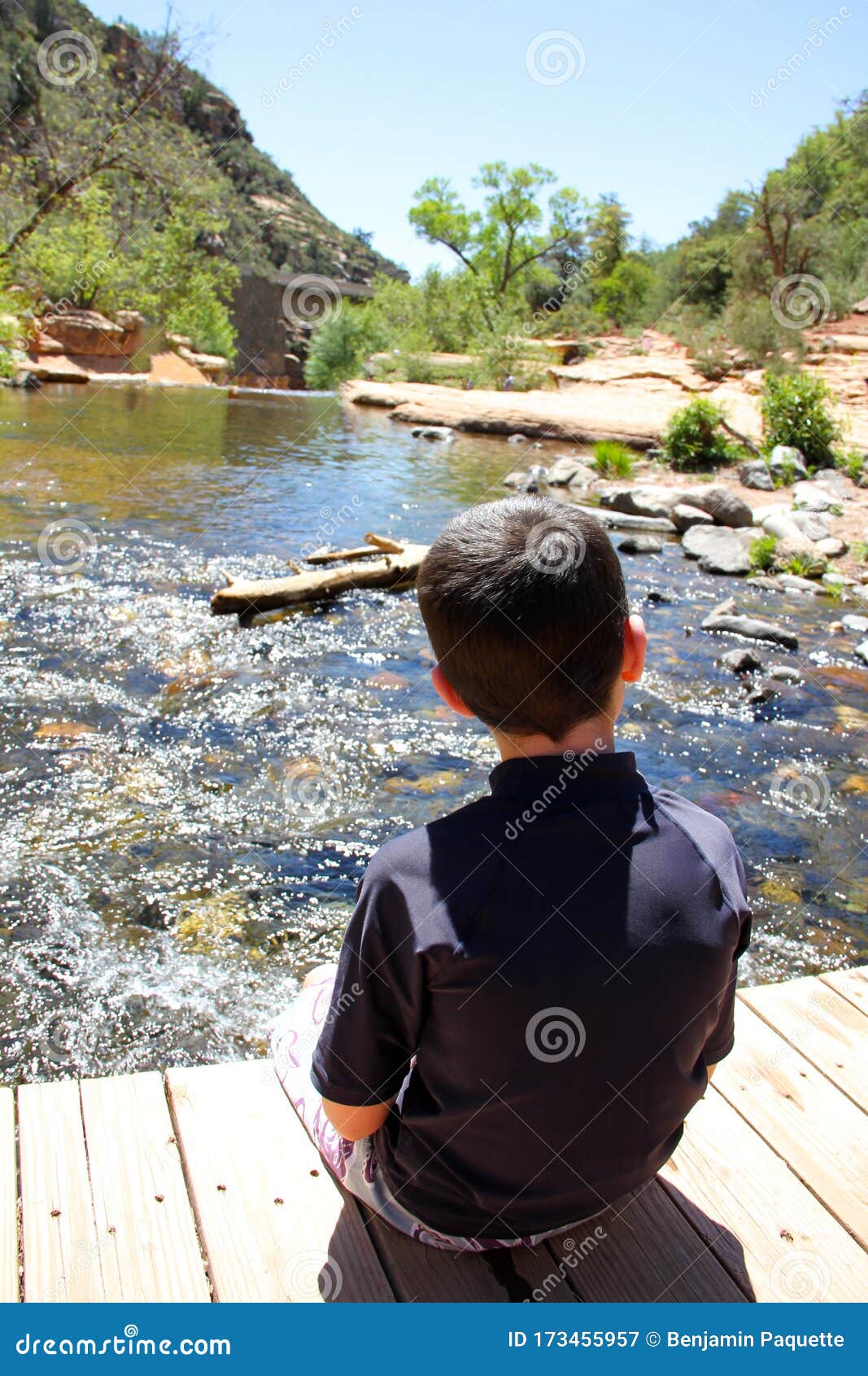 Little Boy Siting on a Bridge Looking at the Water Stock Image - Image ...