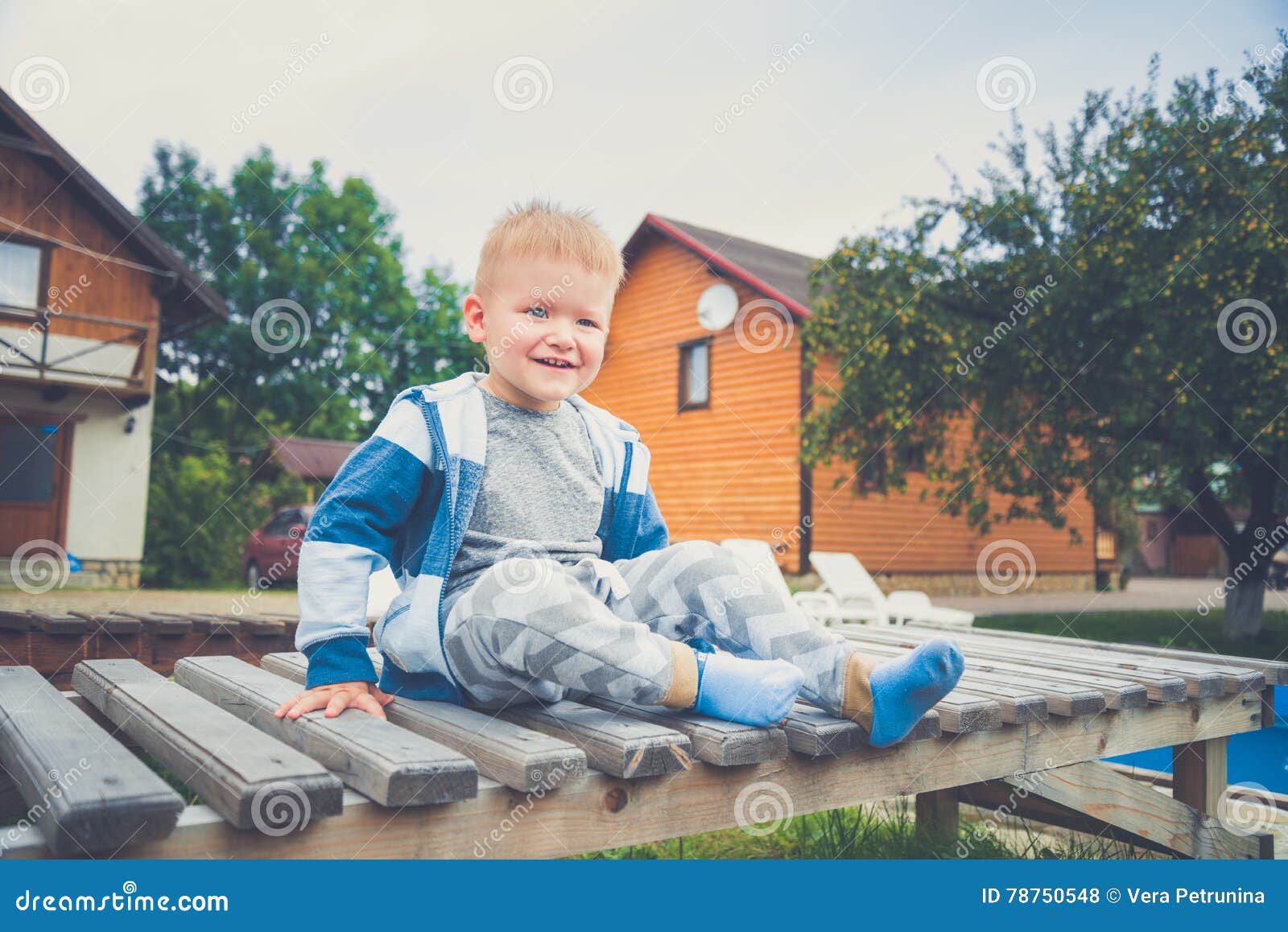 Little Boy Sitting on a Bench Stock Photo - Image of blue, male: 78750548