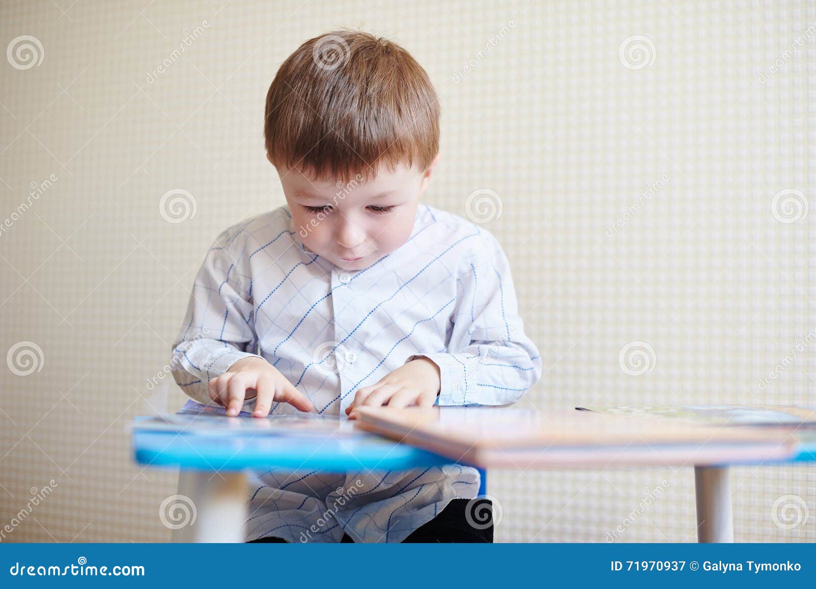 Little Boy Sitting at the Desk and Reading a Book Stock Image - Image ...