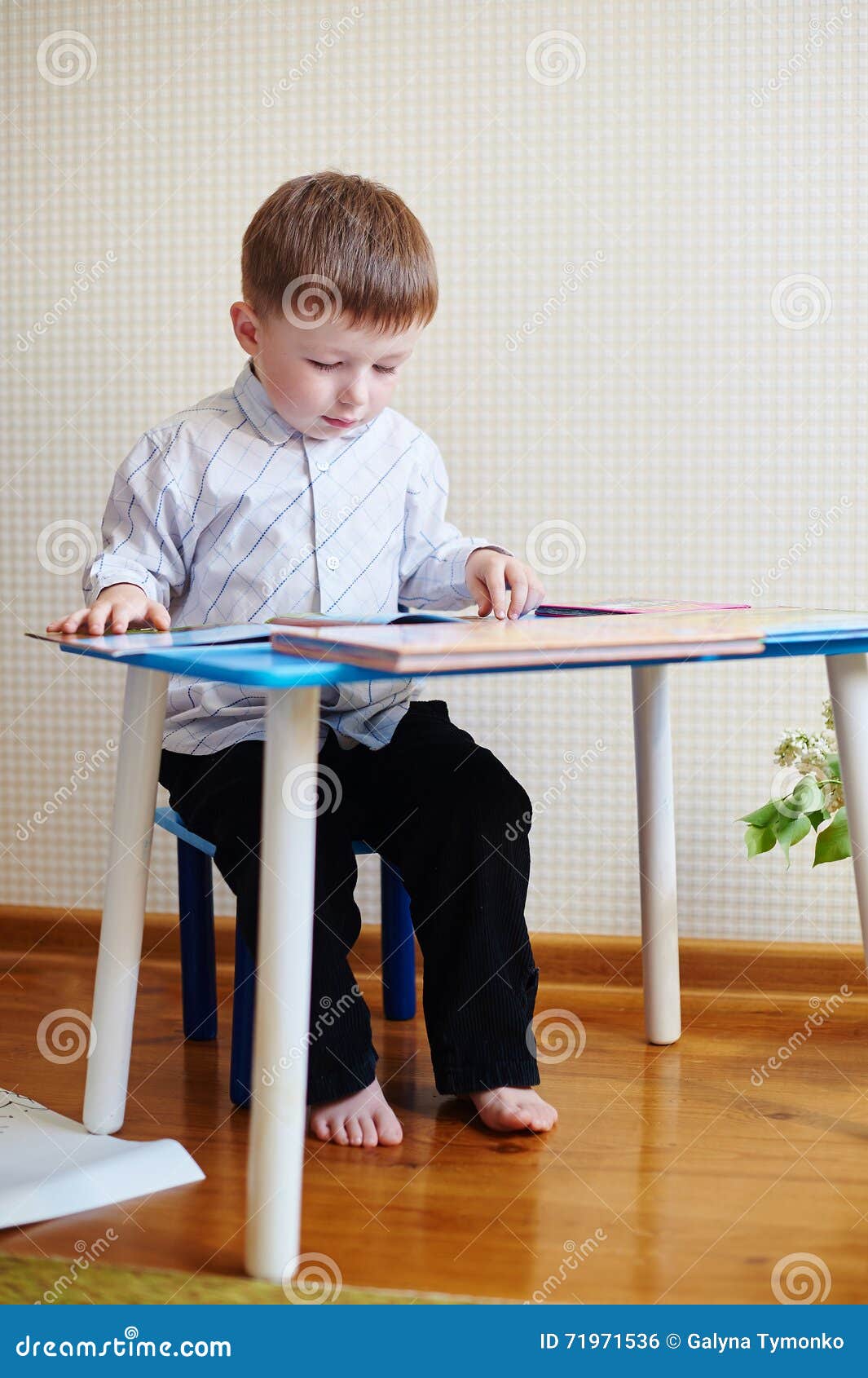 Little Boy Sitting at the Desk and Reading a Book Stock Photo - Image ...