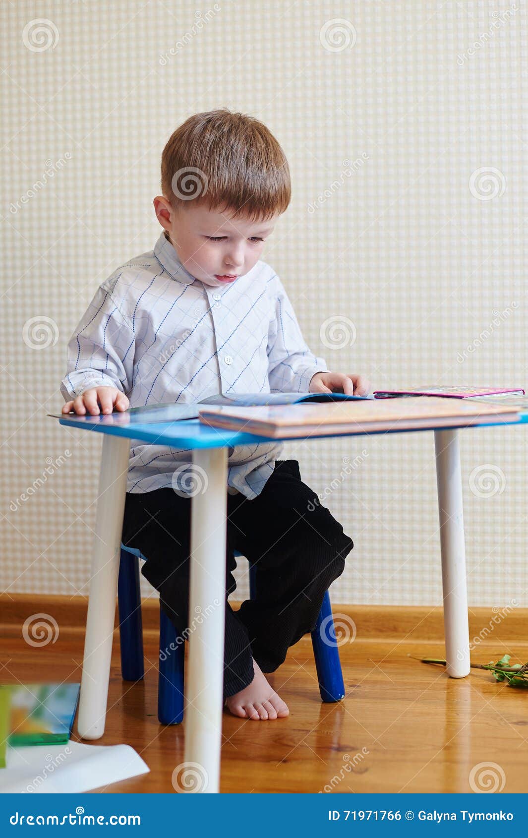 Little Boy Sitting at the Desk and Reading a Book Stock Photo - Image ...