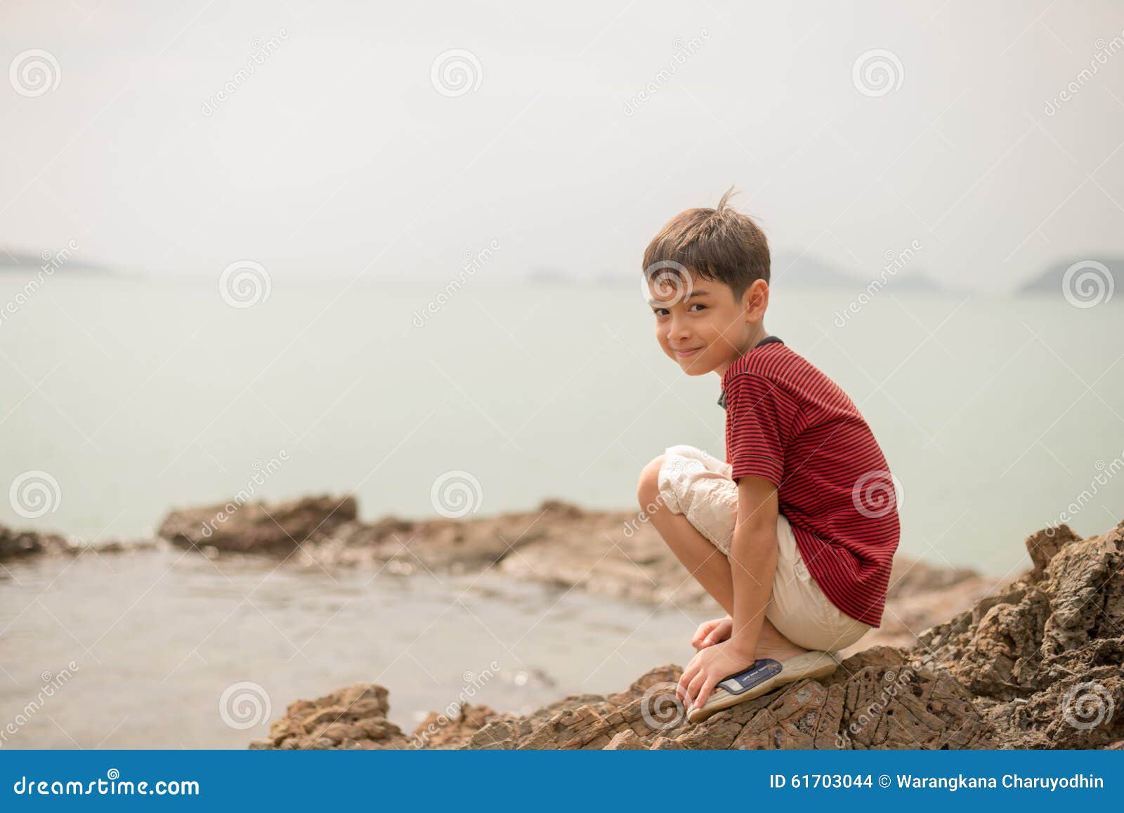 Little Boy Sitting on the Rock on the Beach Face Look Happy Stock Photo ...