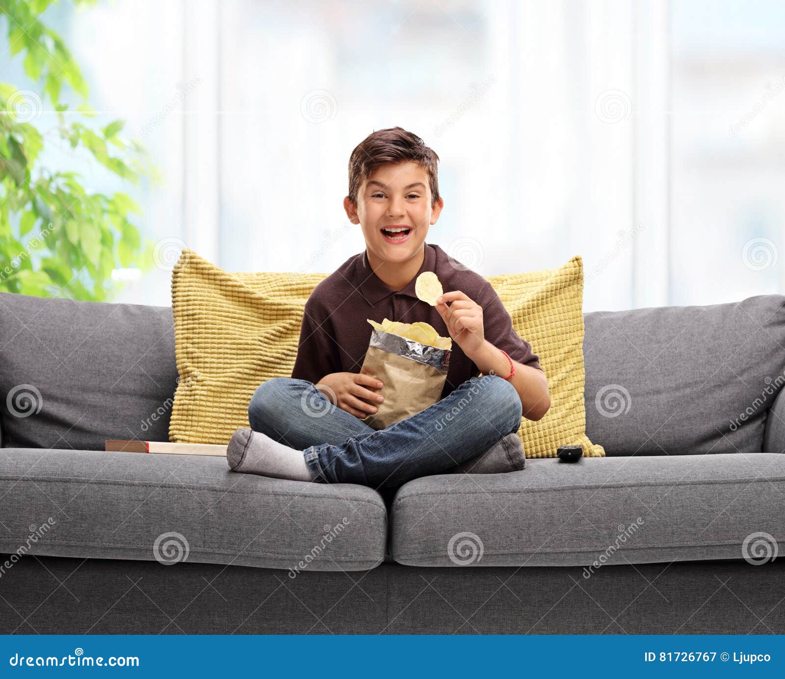 Little Boy Sitting on a Sofa and Eating Potato Chips Stock Image ...