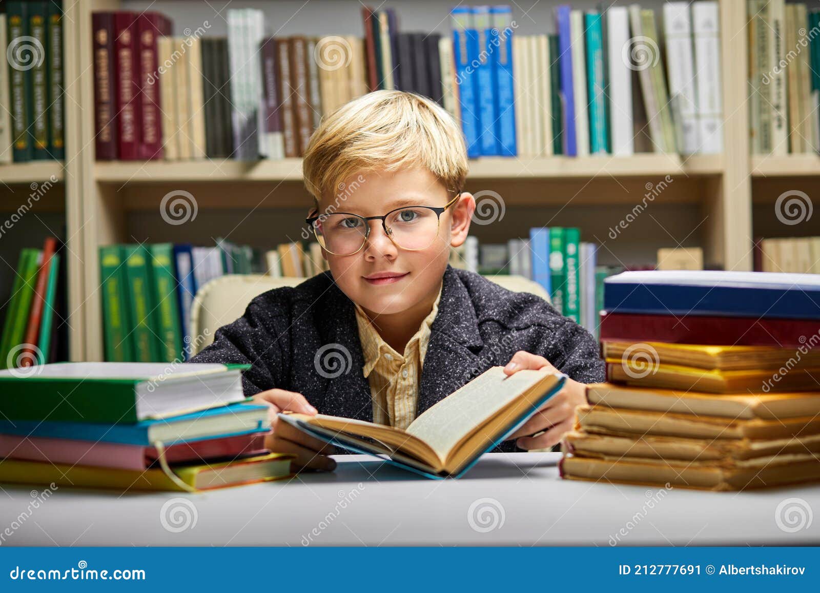 Little Boy Sitting at the Table and Doing School Tasks Surrounded by ...
