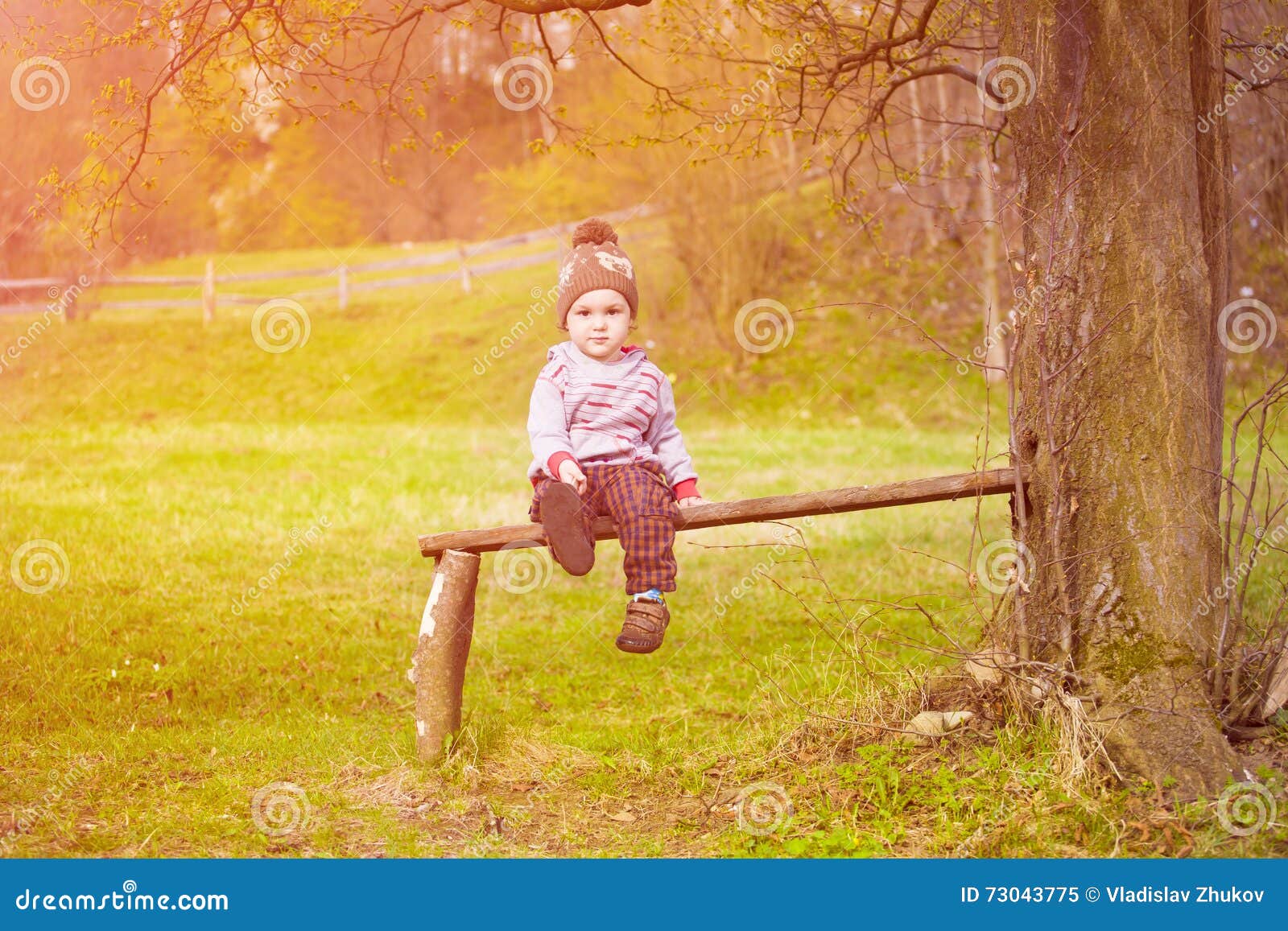 A Little Boy is Sitting Under a Tree. Stock Image - Image of bench ...