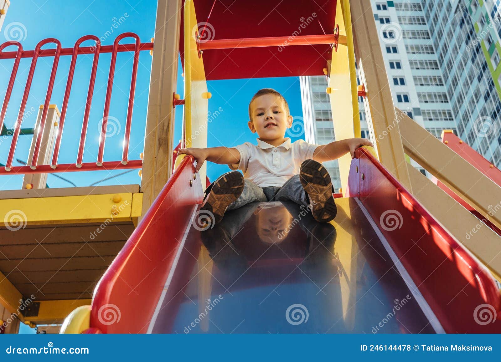 Little Boy Slides Down the Slide at Playground. Stock Photo - Image of ...