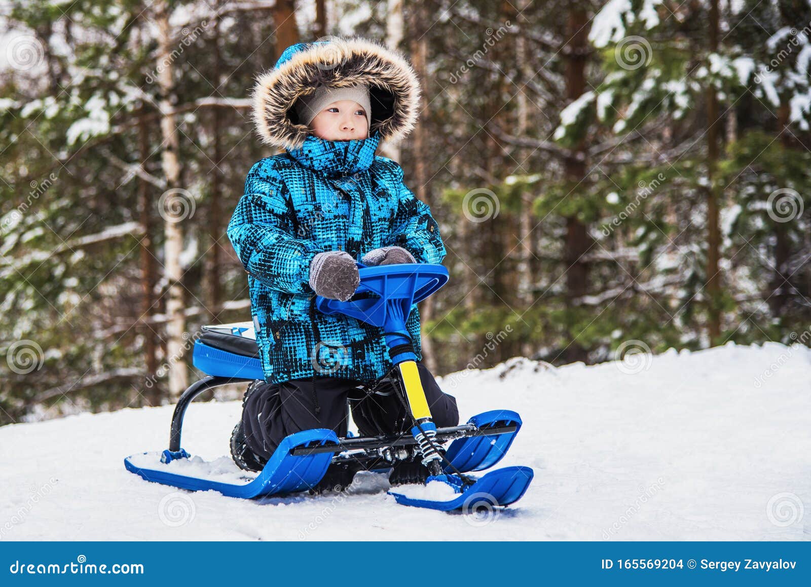 Little boy on snowscooter stock photo. Image of sitting - 165569204