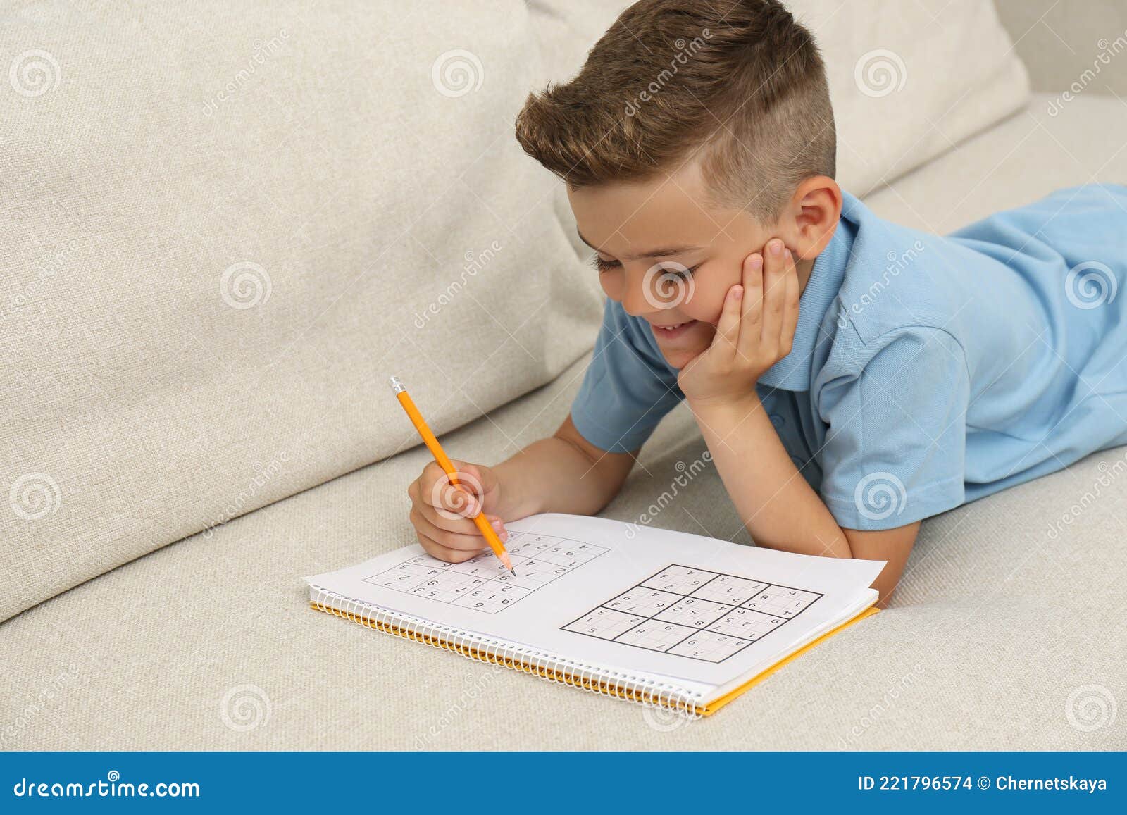 Little Boy Solving Sudoku Puzzle on Sofa Stock Photo - Image of ...