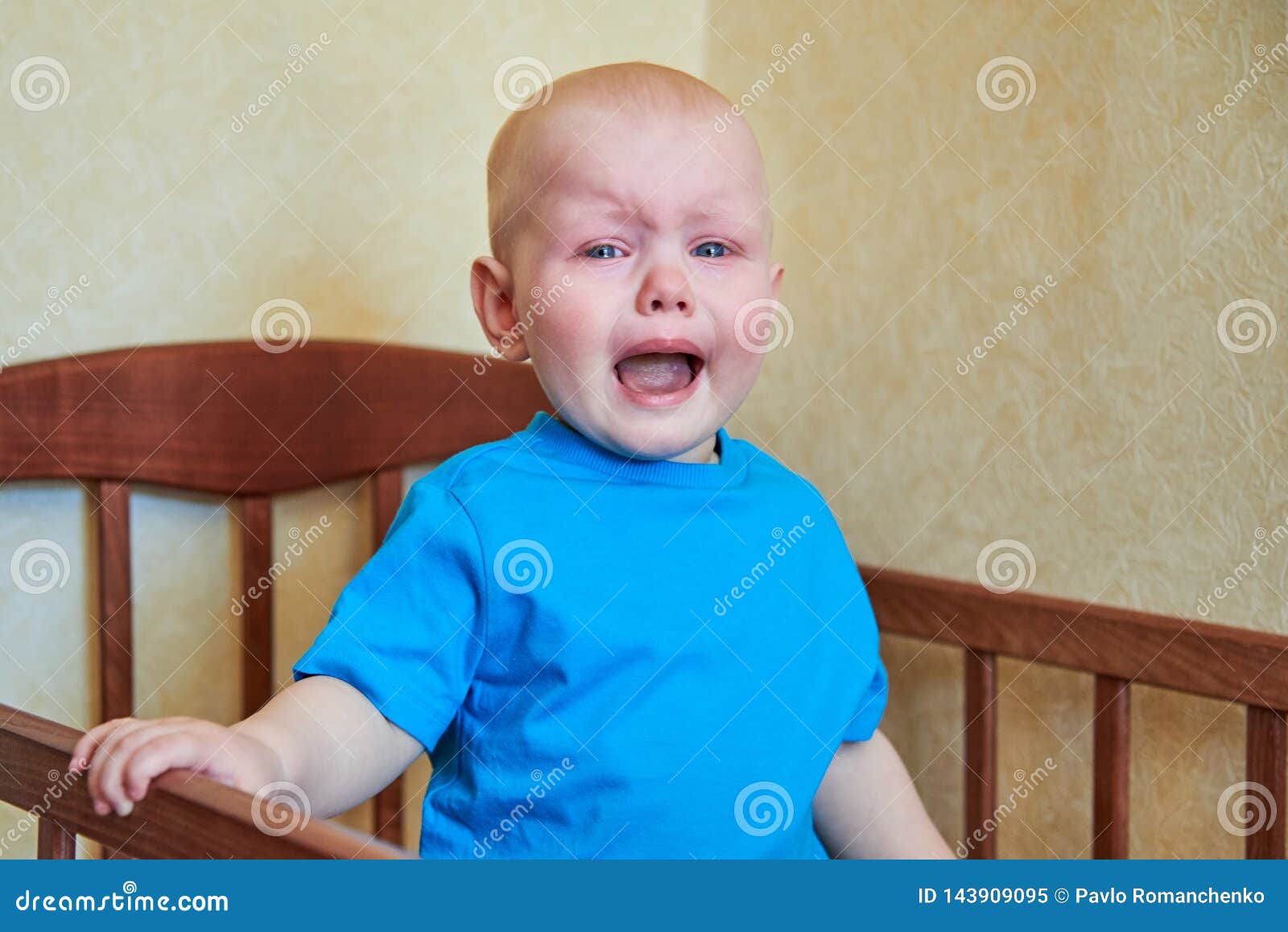 A Little Boy is Standing in the Crib, Crying and Calling Mother Stock ...