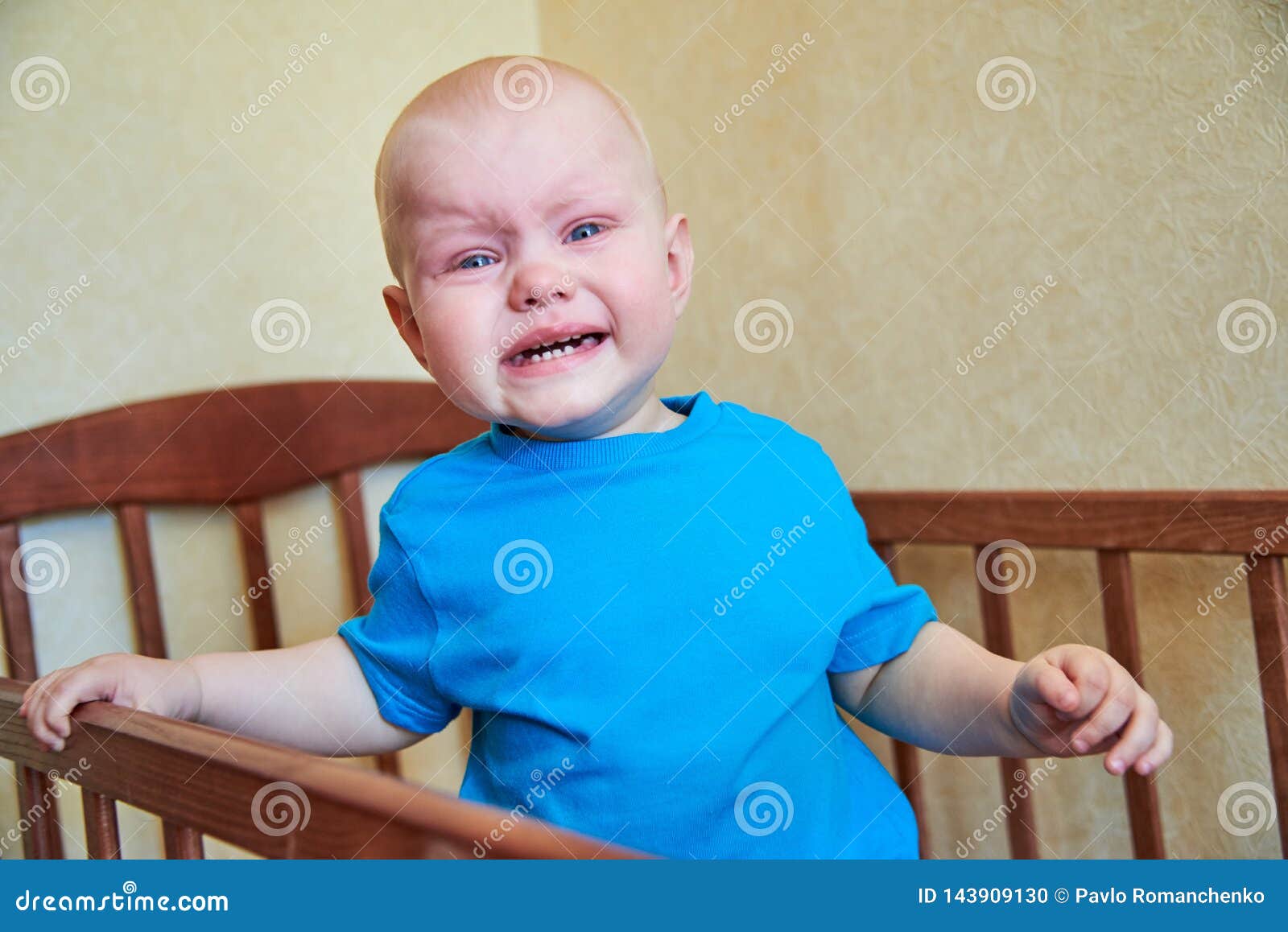 A Little Boy is Standing in the Crib, Crying and Calling Mother Stock ...