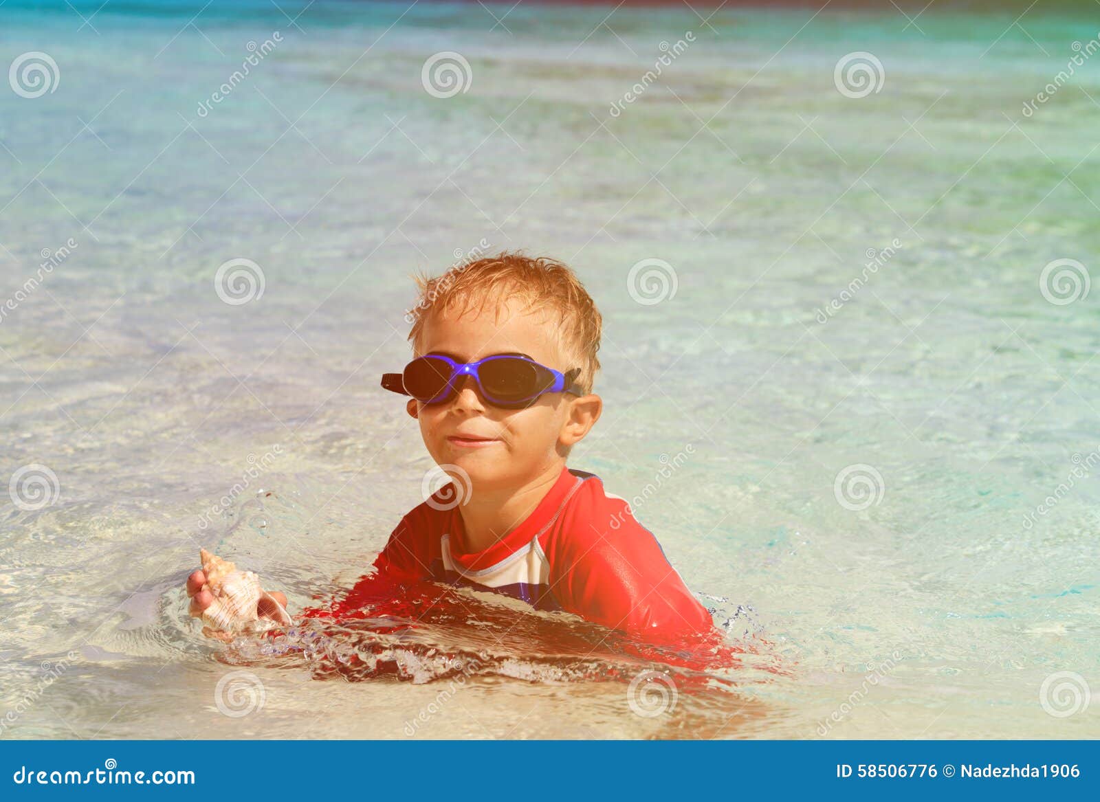 Little Boy Swimming Holding Shell on Beach Stock Photo - Image of shore ...